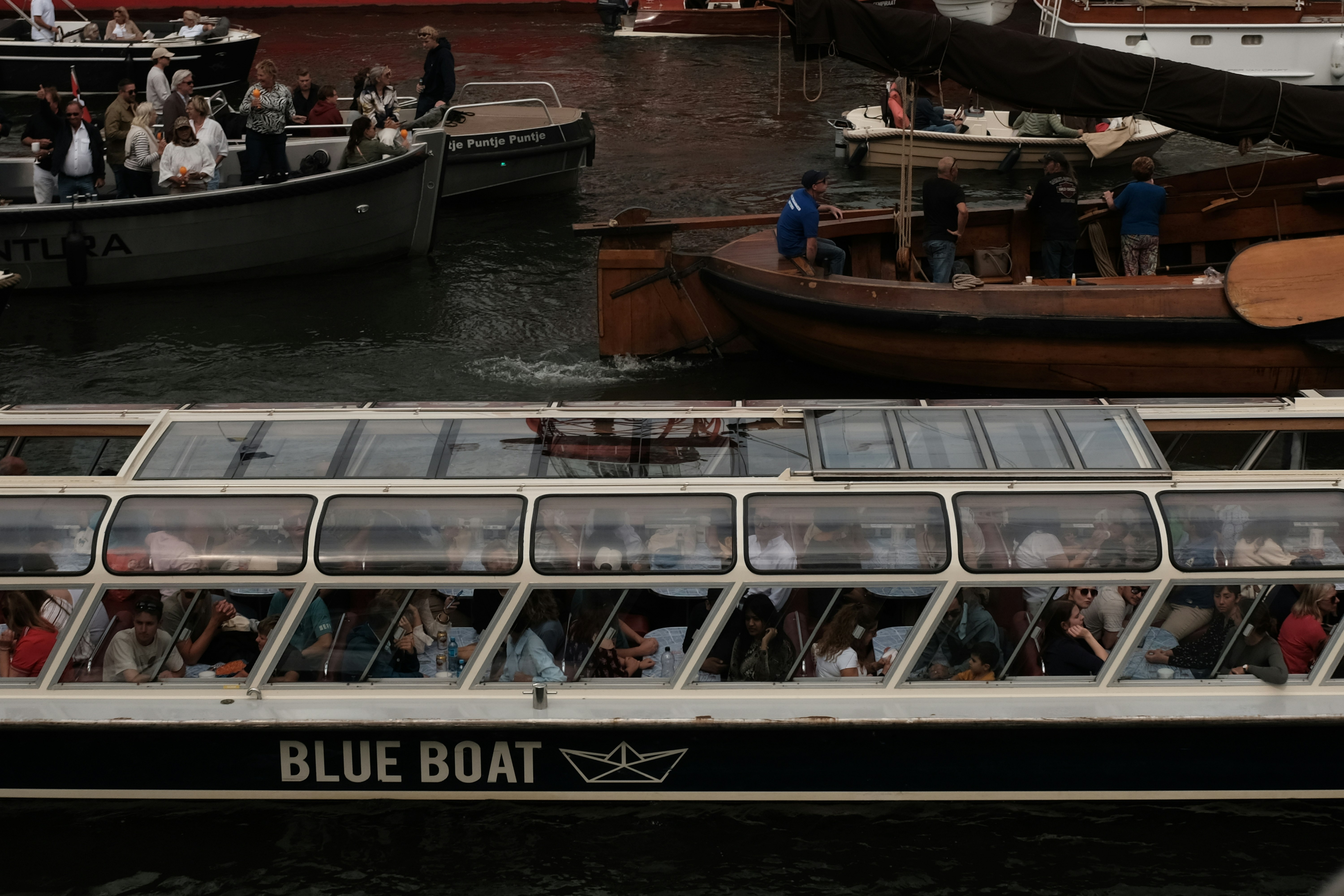 Canal Crowds Under the Glass Roof: Passengers Aboard the Blue Boat