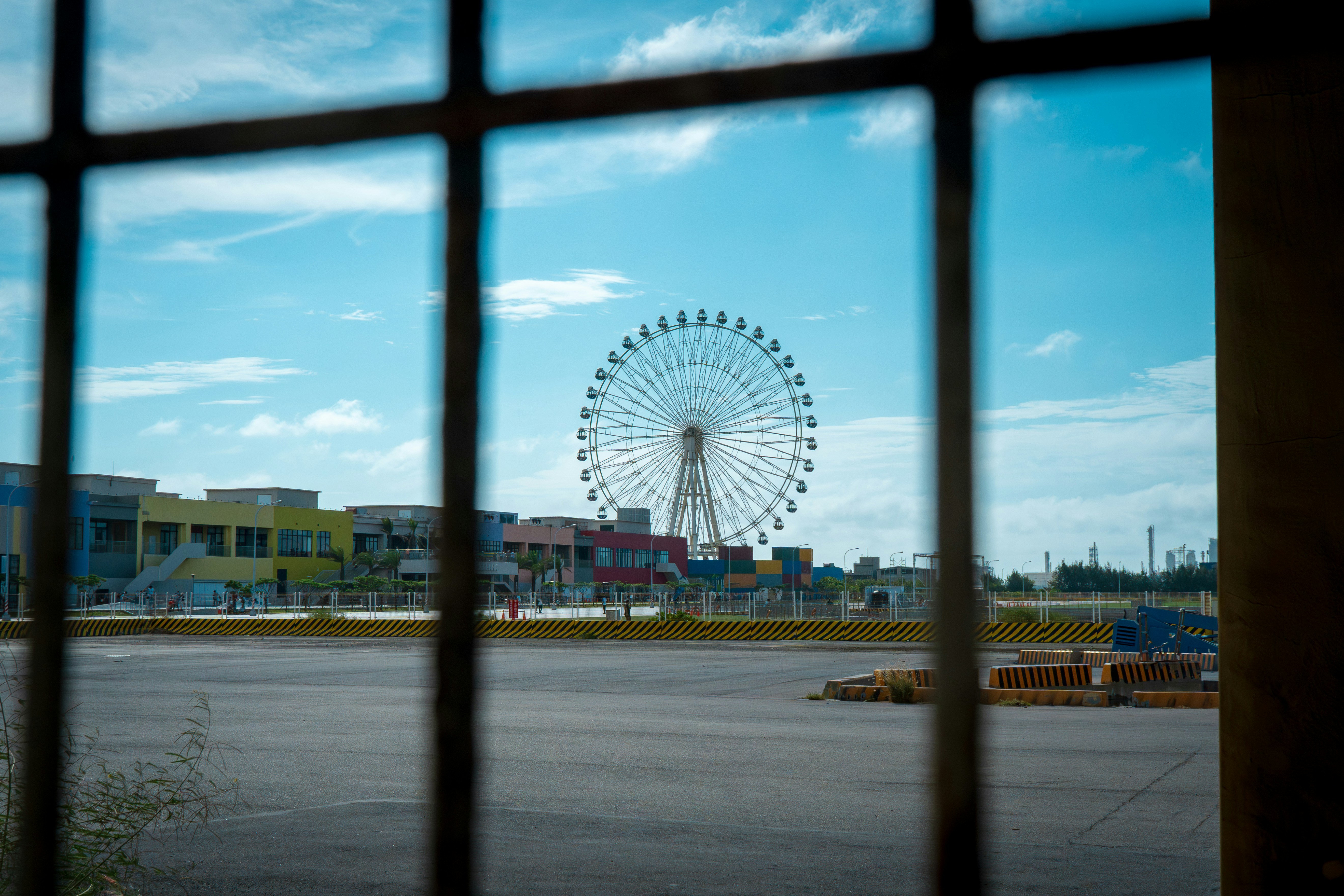 The distant Ferris wheel and the colorful world, while I am a caged bird. | Ferris wheel seen through a window frame