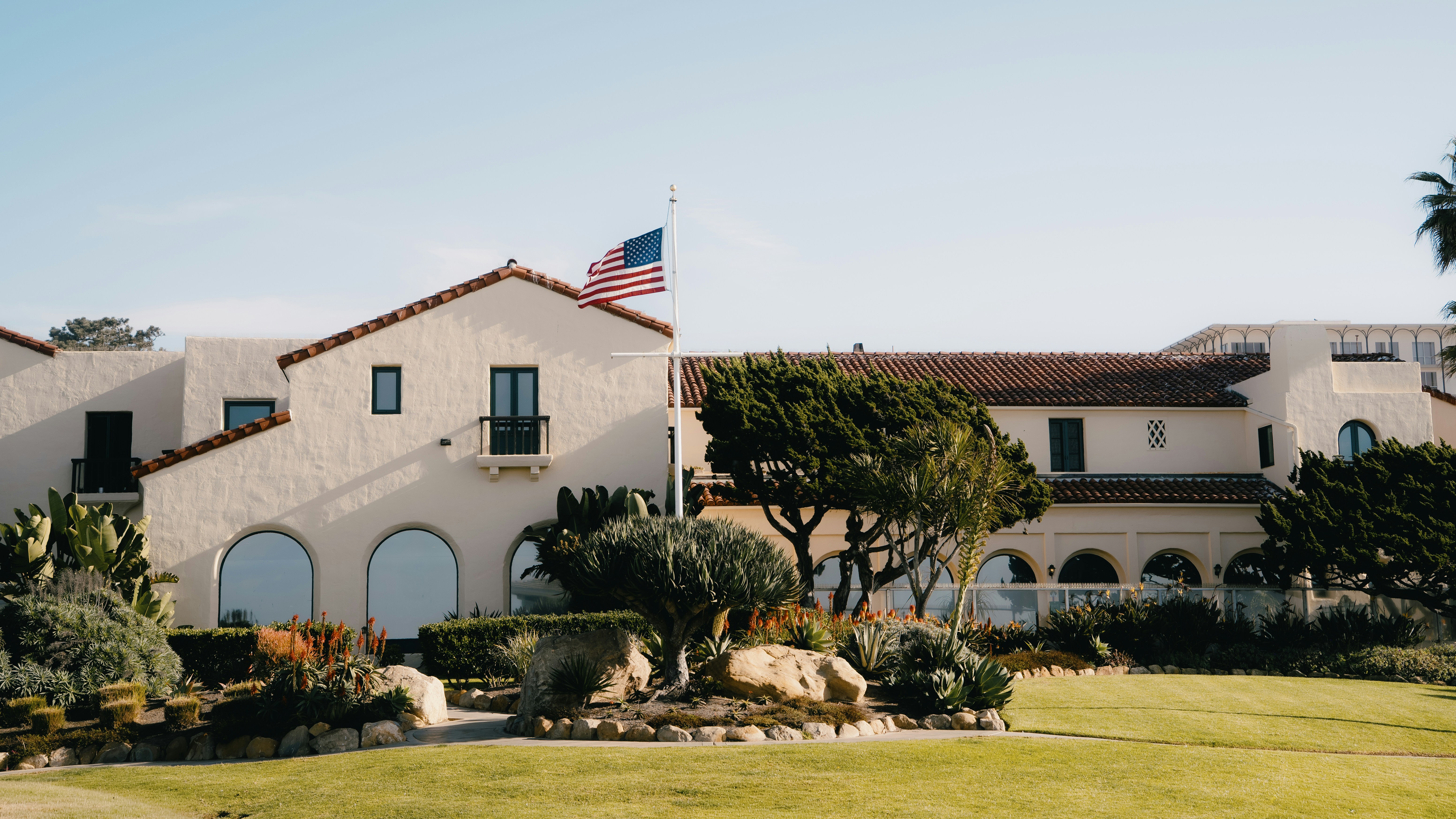 Large building with spanish architecture and american flag.