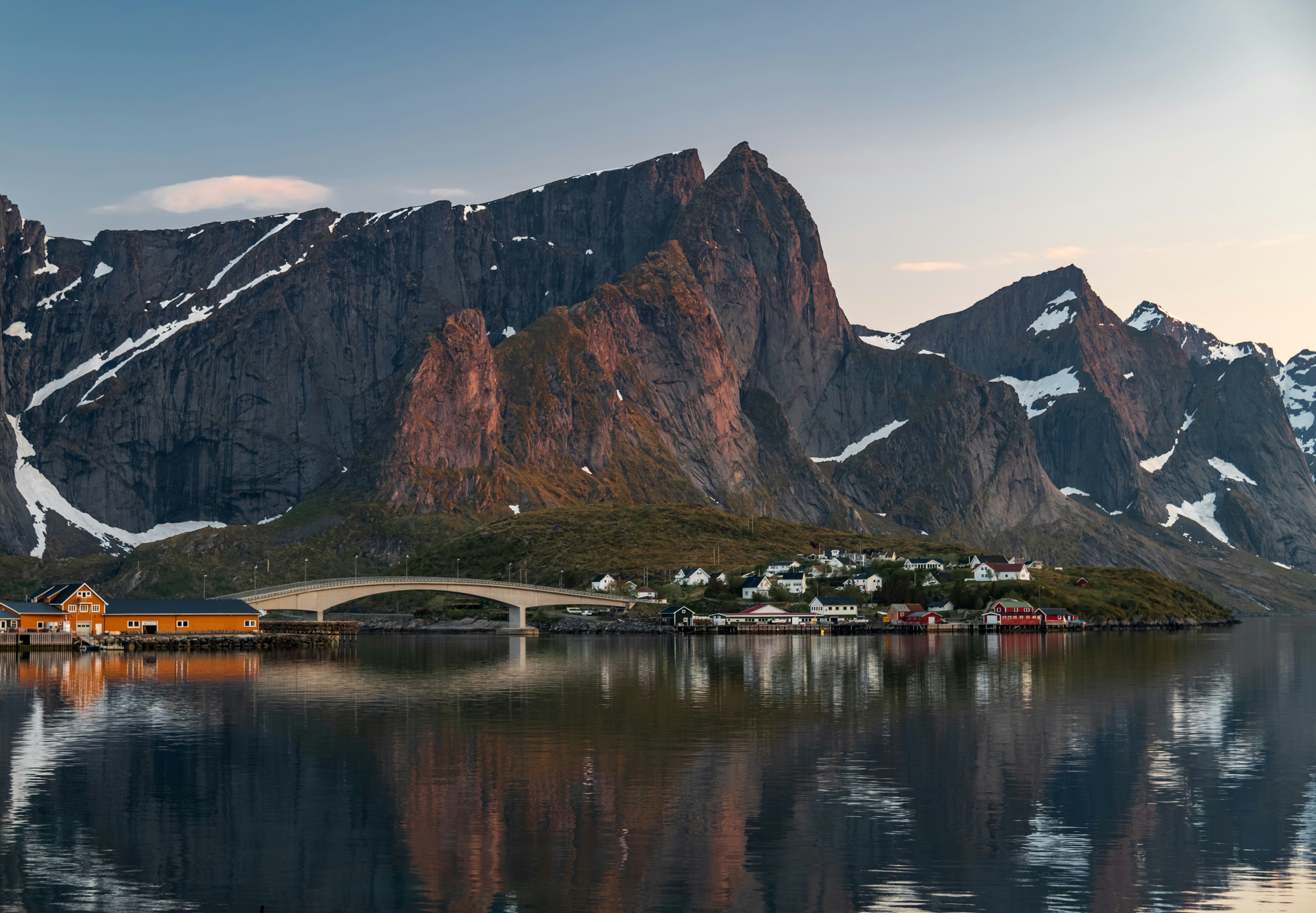 Coastal village nestled beneath dramatic, snow-capped mountains.