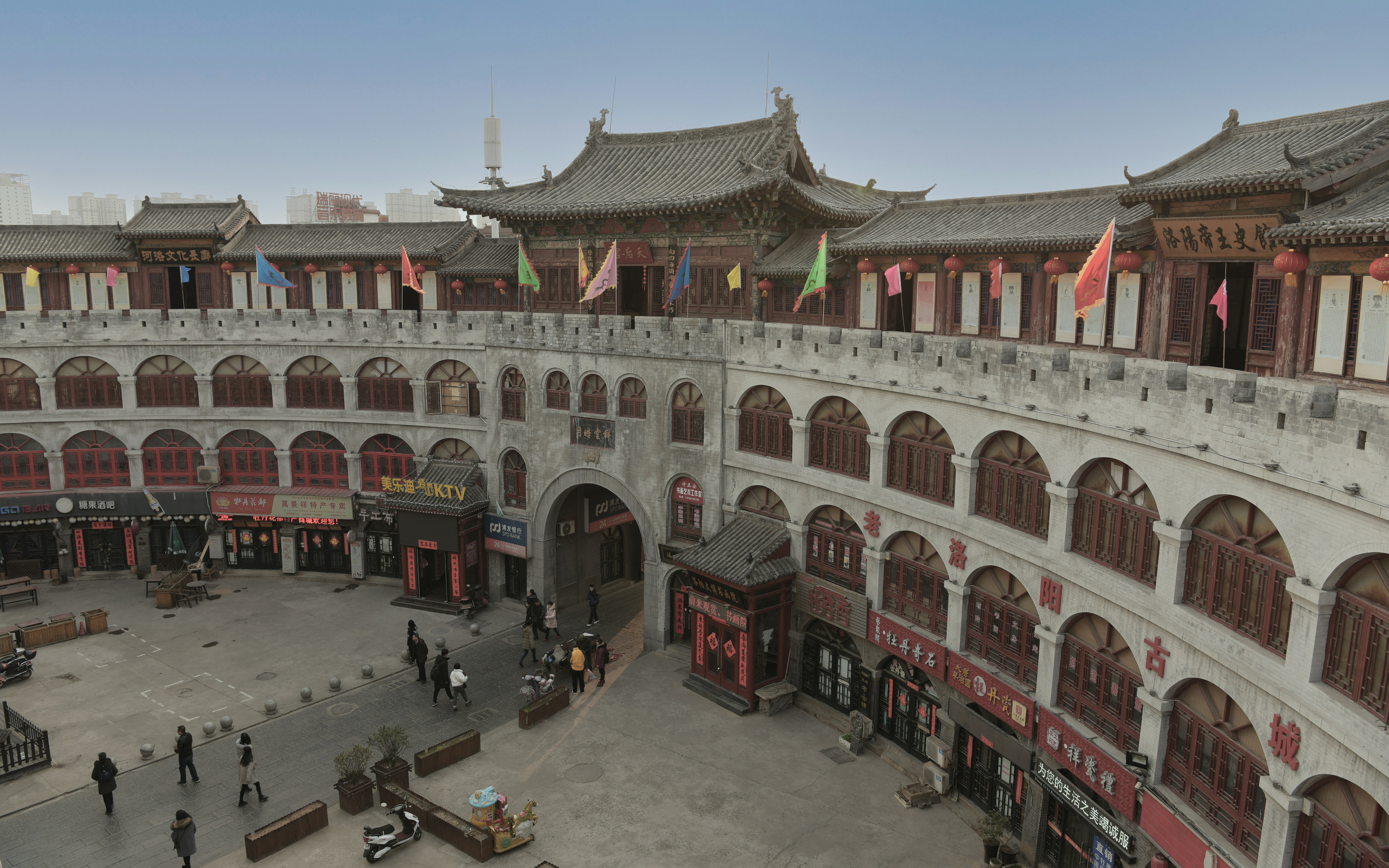 Sunlit Arched Arcade: Heritage Courtyard Framed by a Modern Skyline