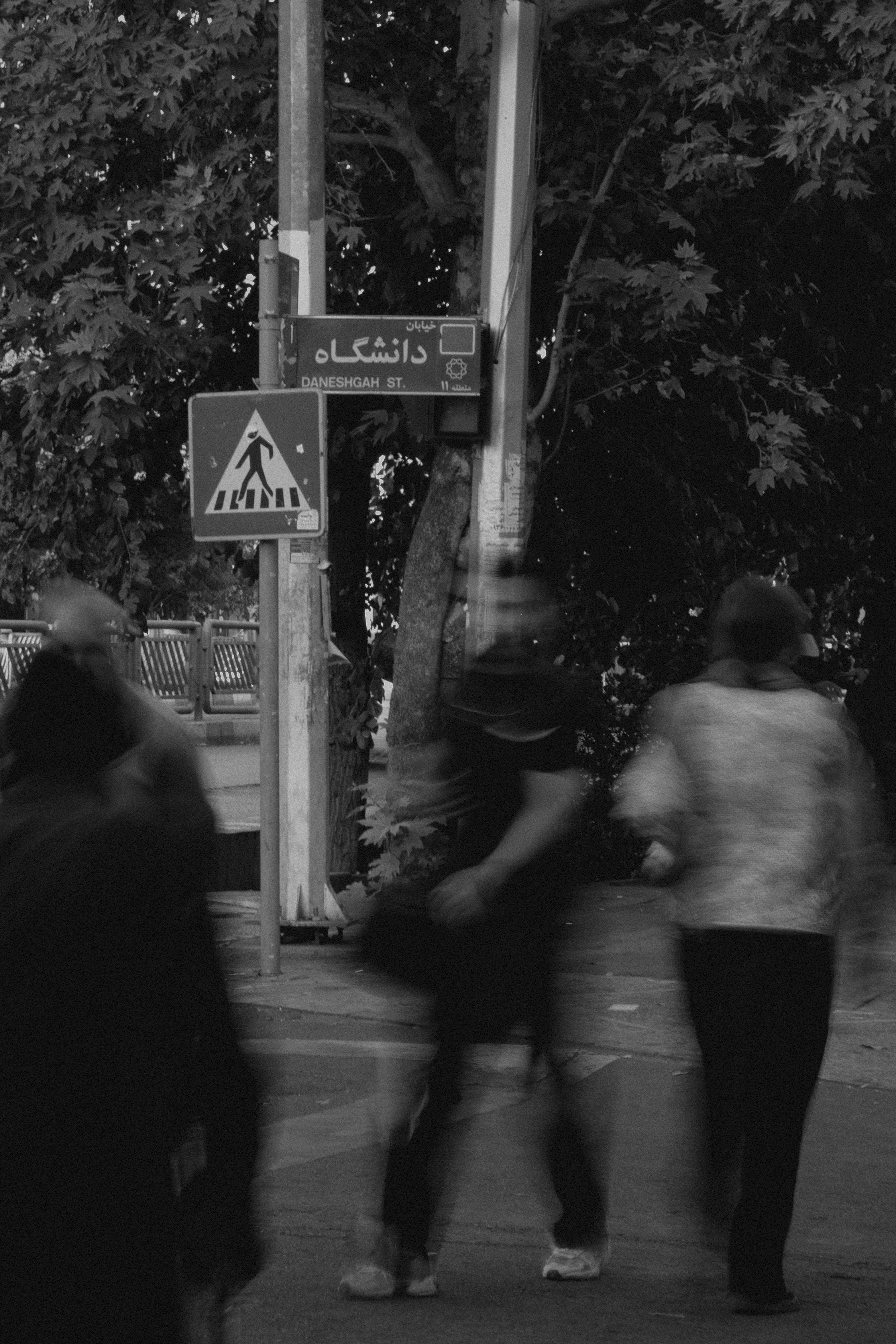 People blurred by motion crossing a street