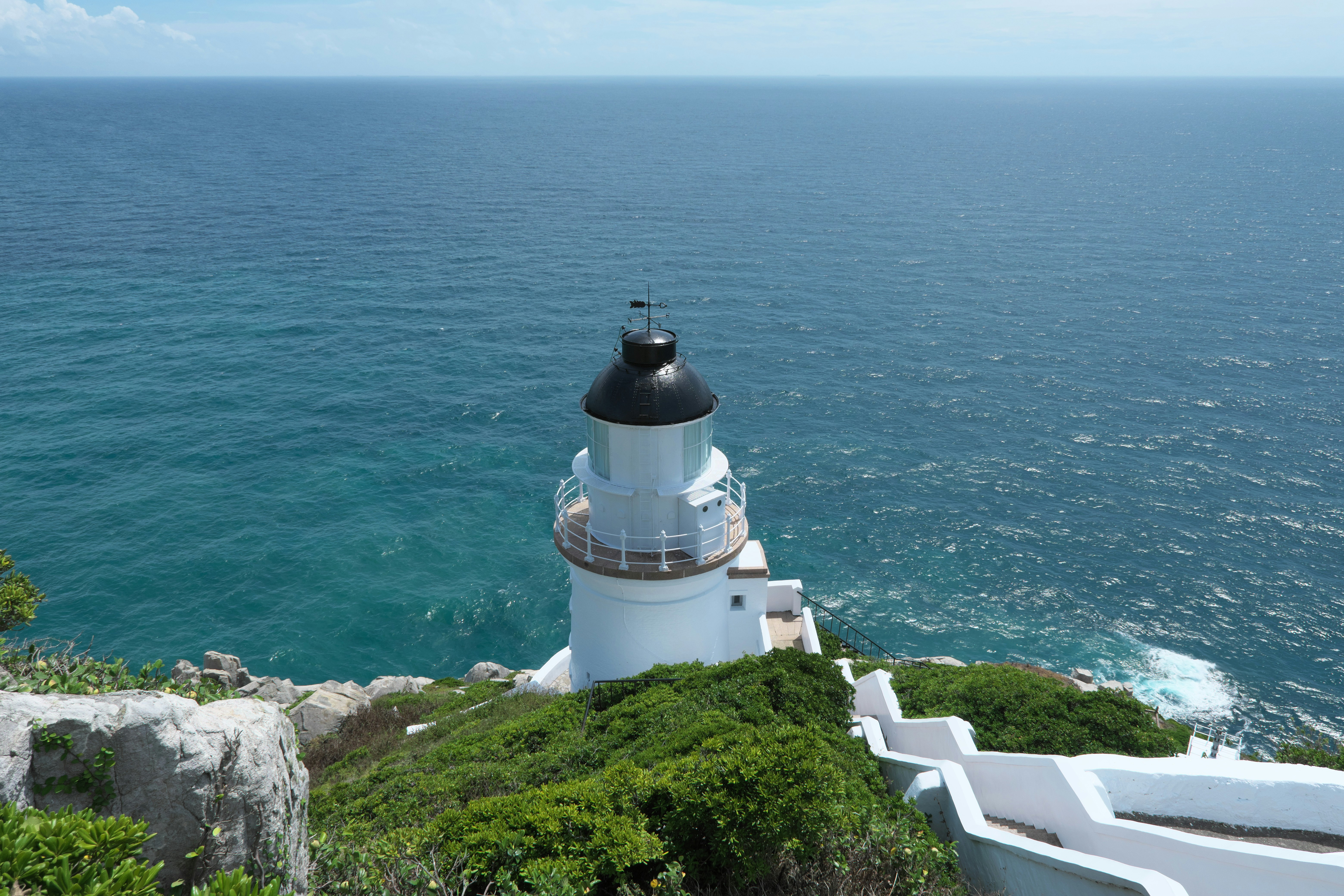 White lighthouse on a cliff overlooking the ocean