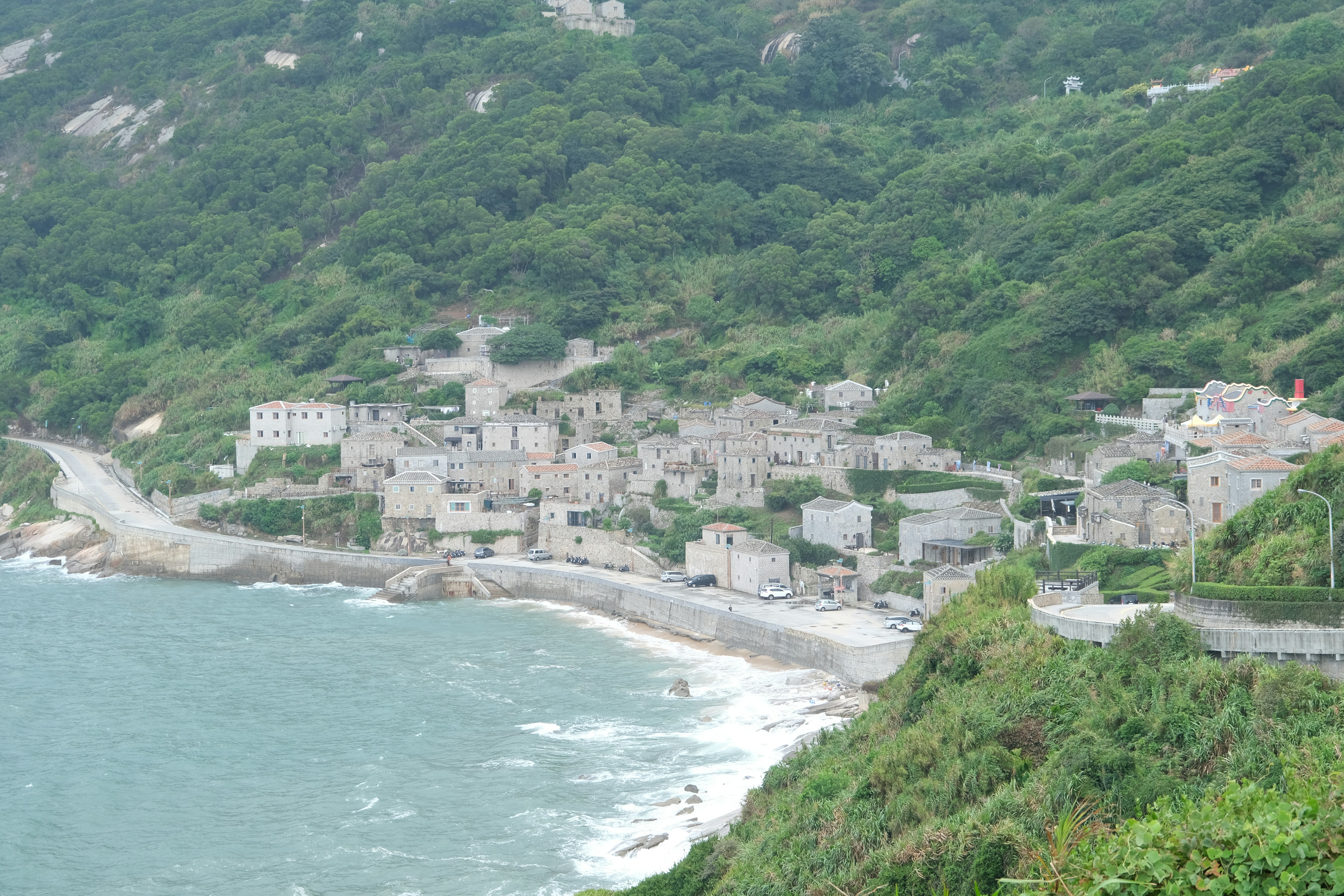 Stone Village by the Sea: White-Washed Homes Along a Green Shoreline