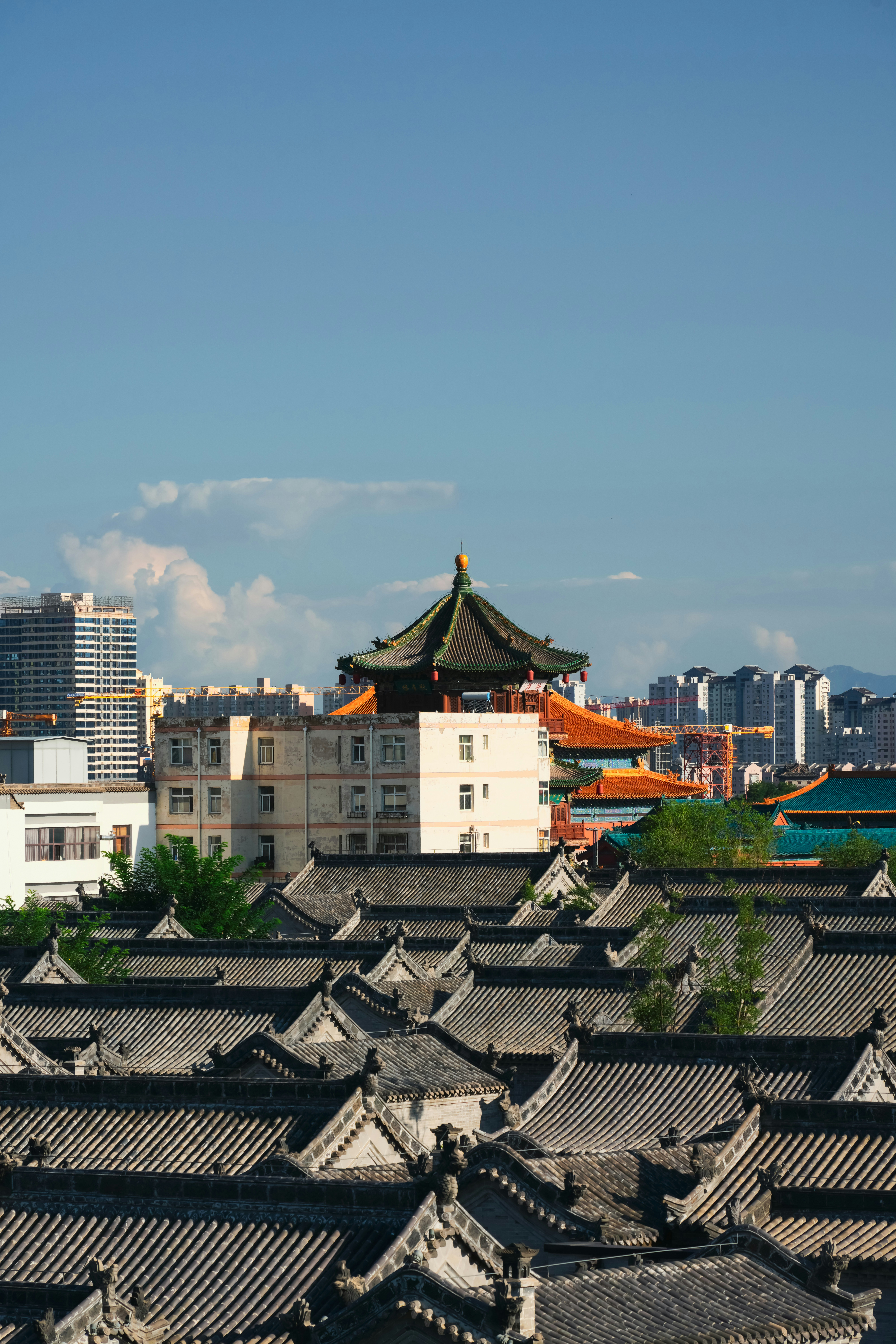 Traditional tiled roofs with modern buildings in background.