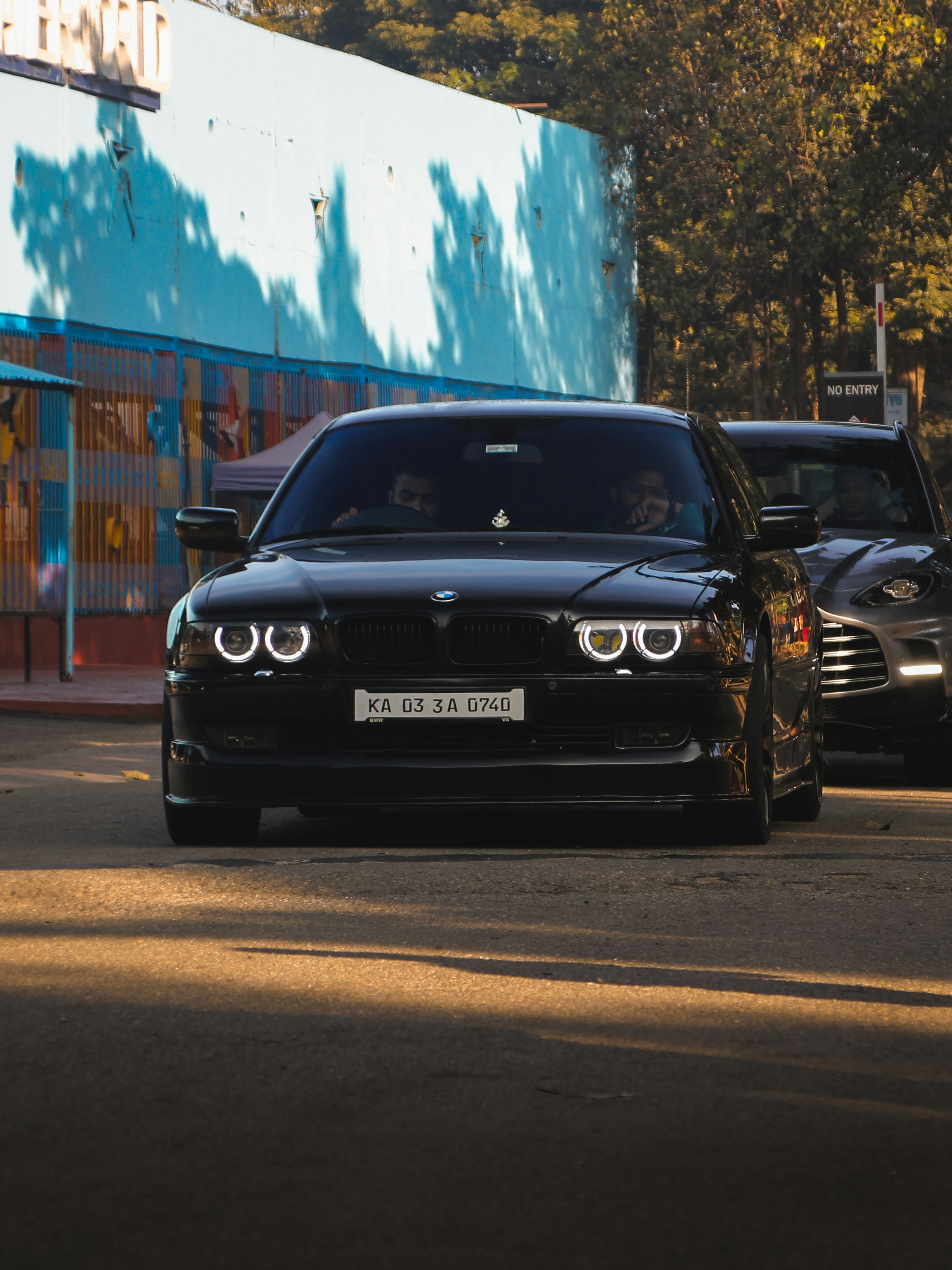 Black luxury sedan with glowing headlights on road