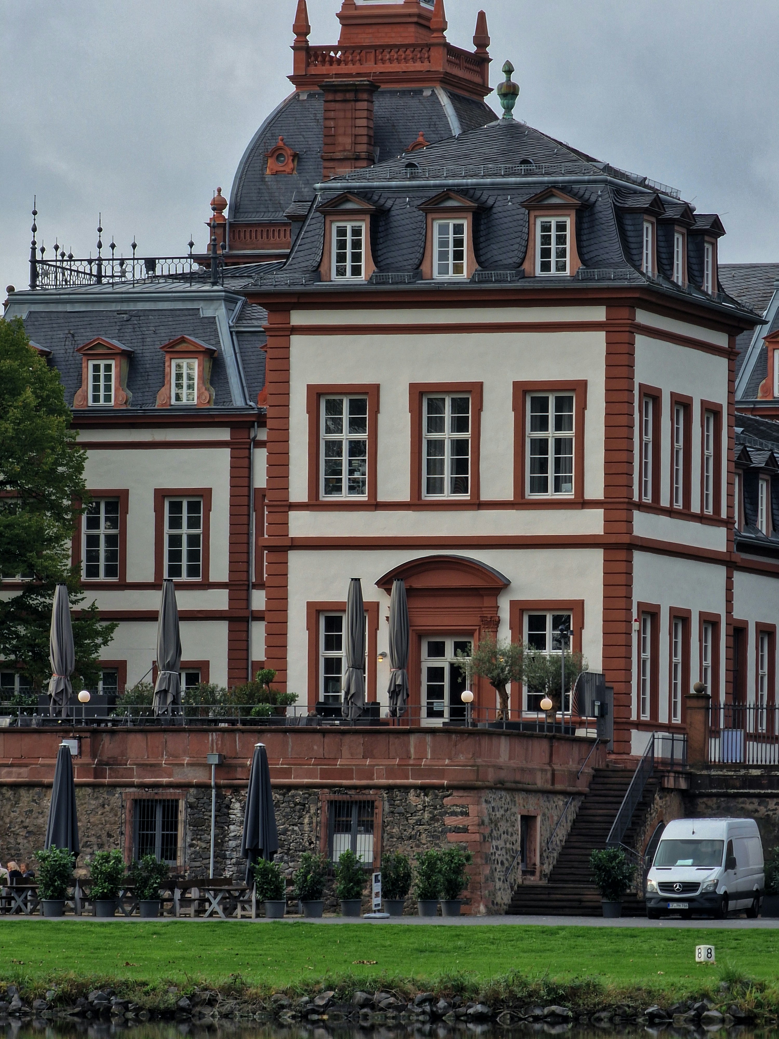 Ornate historic building with red accents and dormer windows.