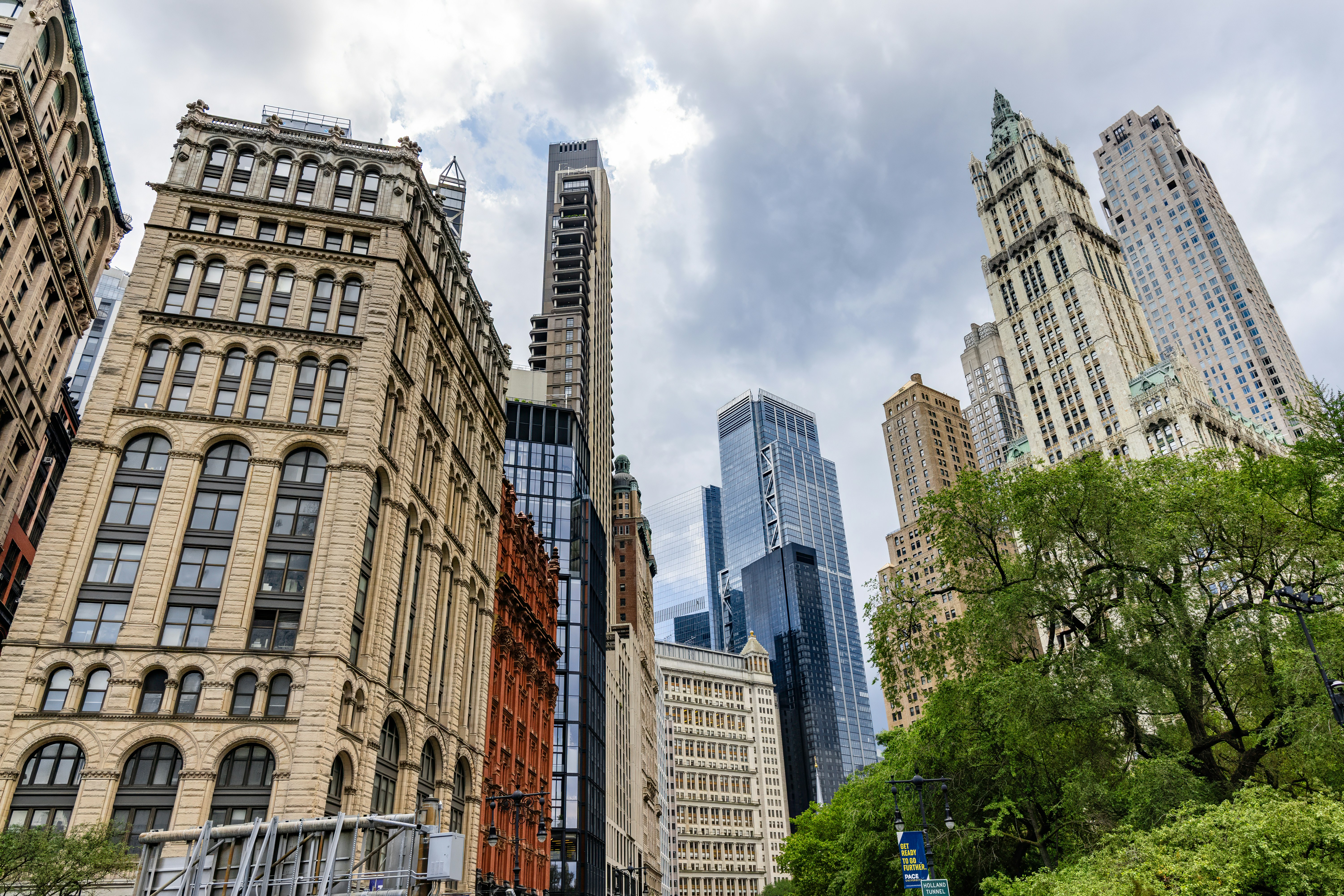 Skyscrapers rise against a cloudy sky in a city.