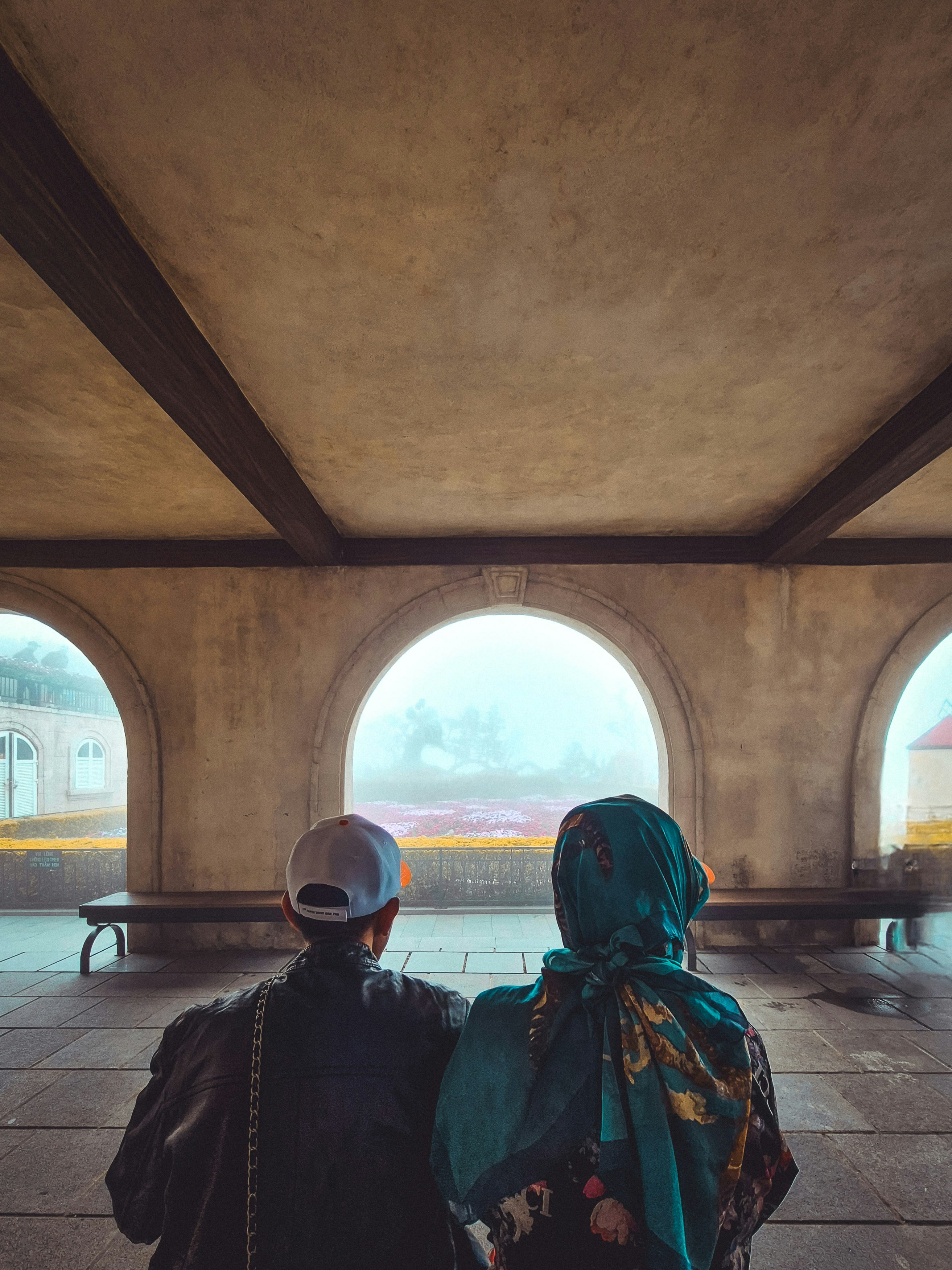 Two people look out at a foggy landscape.