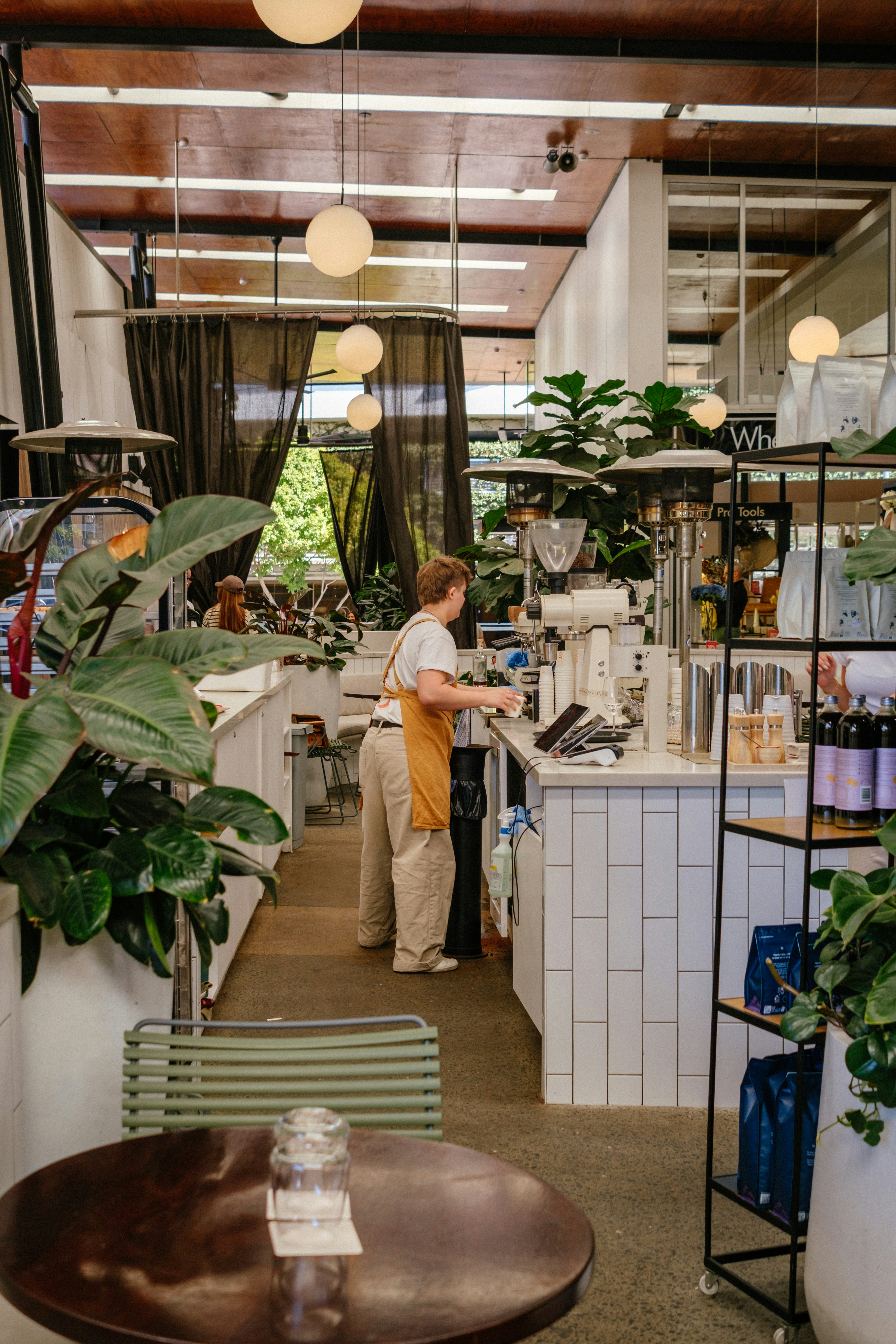 Barista working behind counter in modern cafe