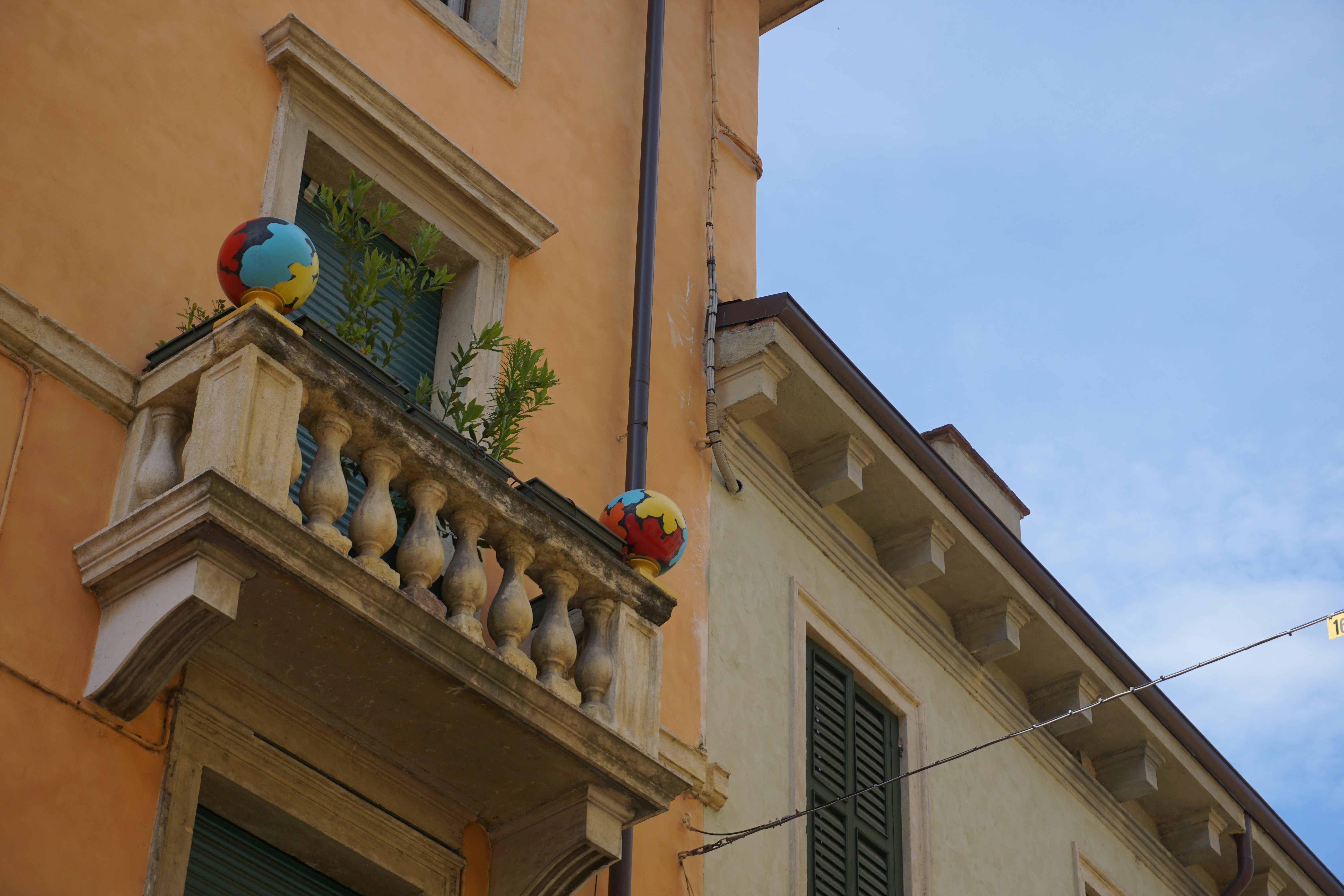 Two globes on a balcony railing.