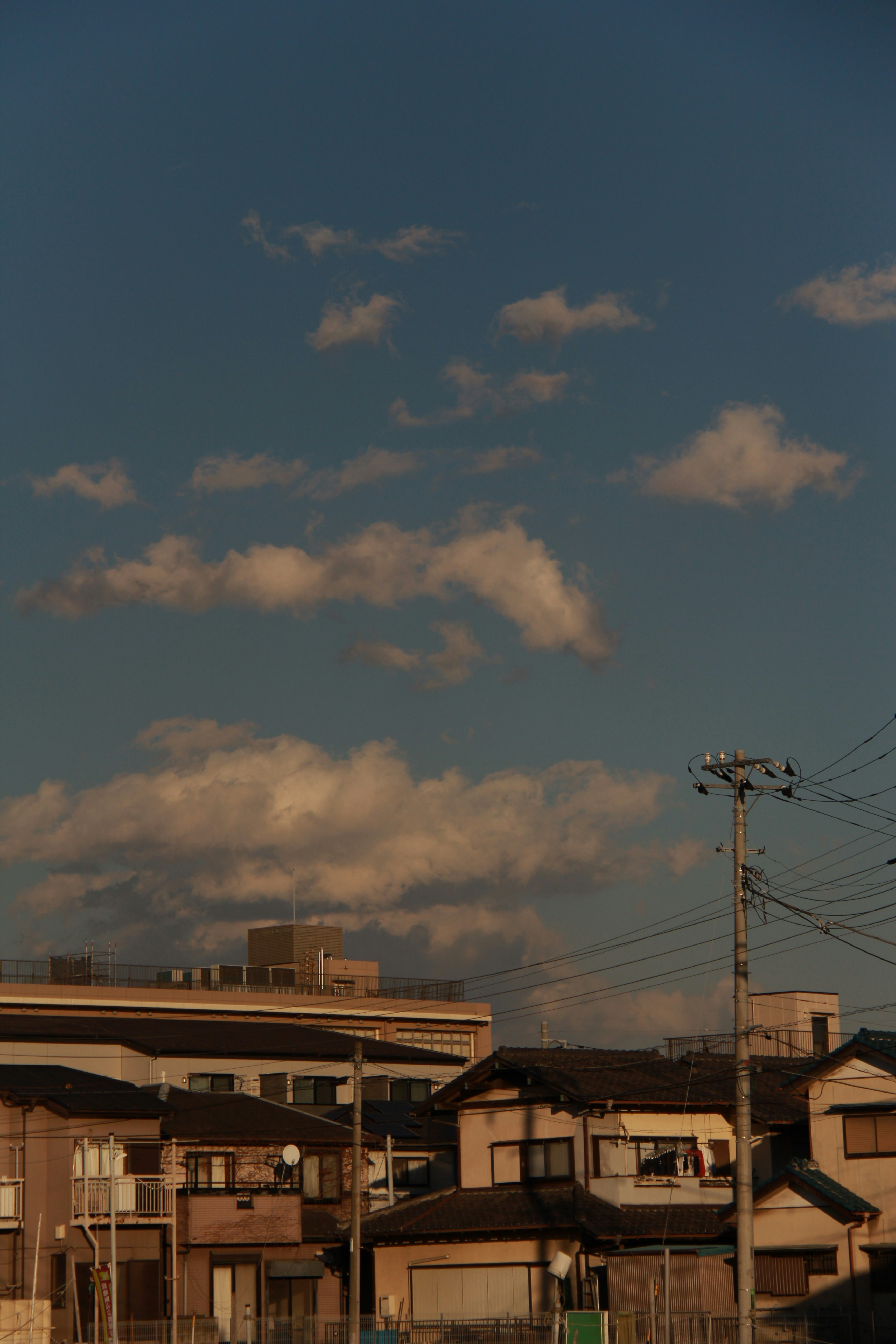 Picture of the sky and buildings in the evening. | Residential buildings under a cloudy sky at dusk