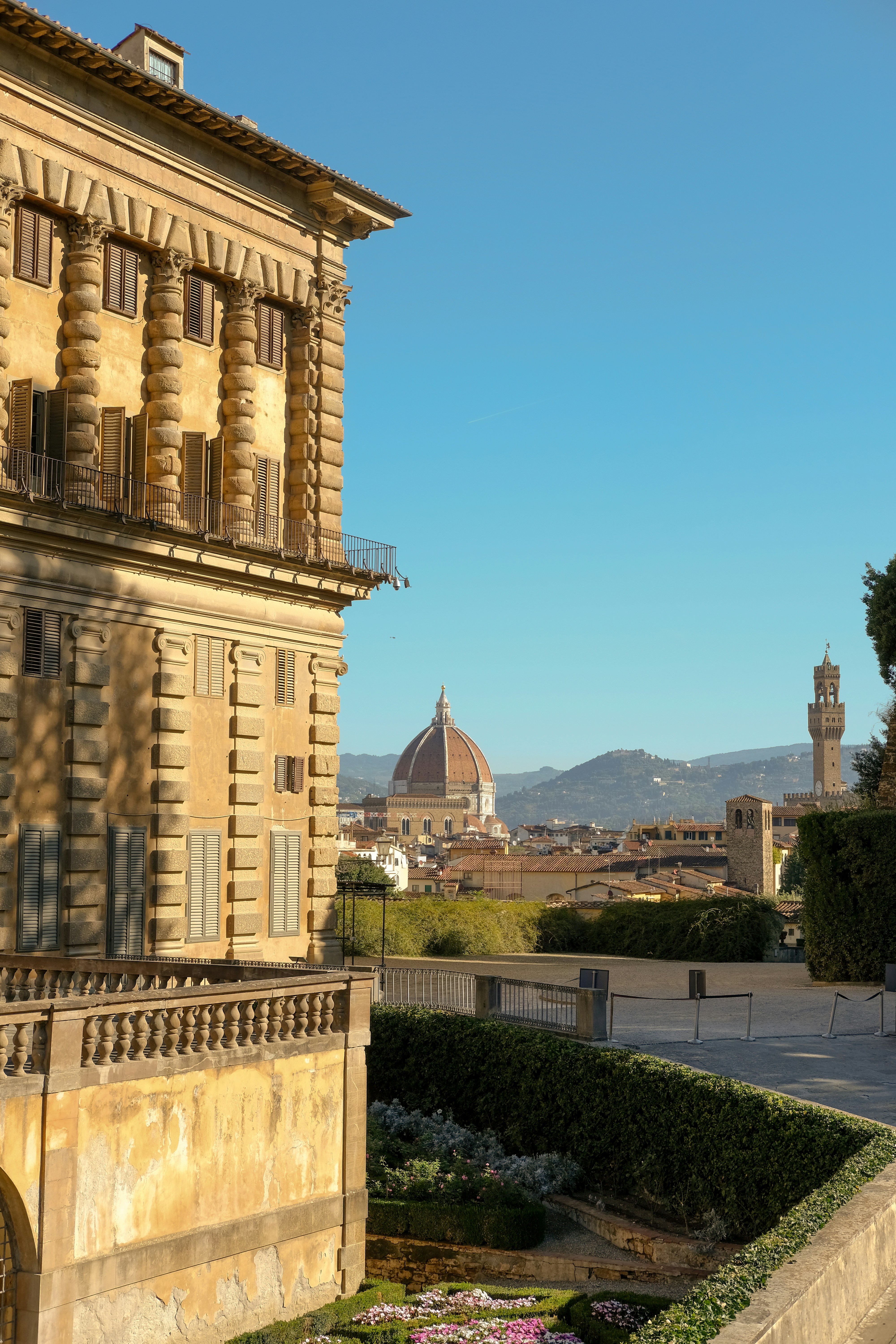 Historic architecture framing the iconic dome of Florence's cathedral, with lush gardens in the foreground. A serene view capturing the essence of the city's rich heritage.
