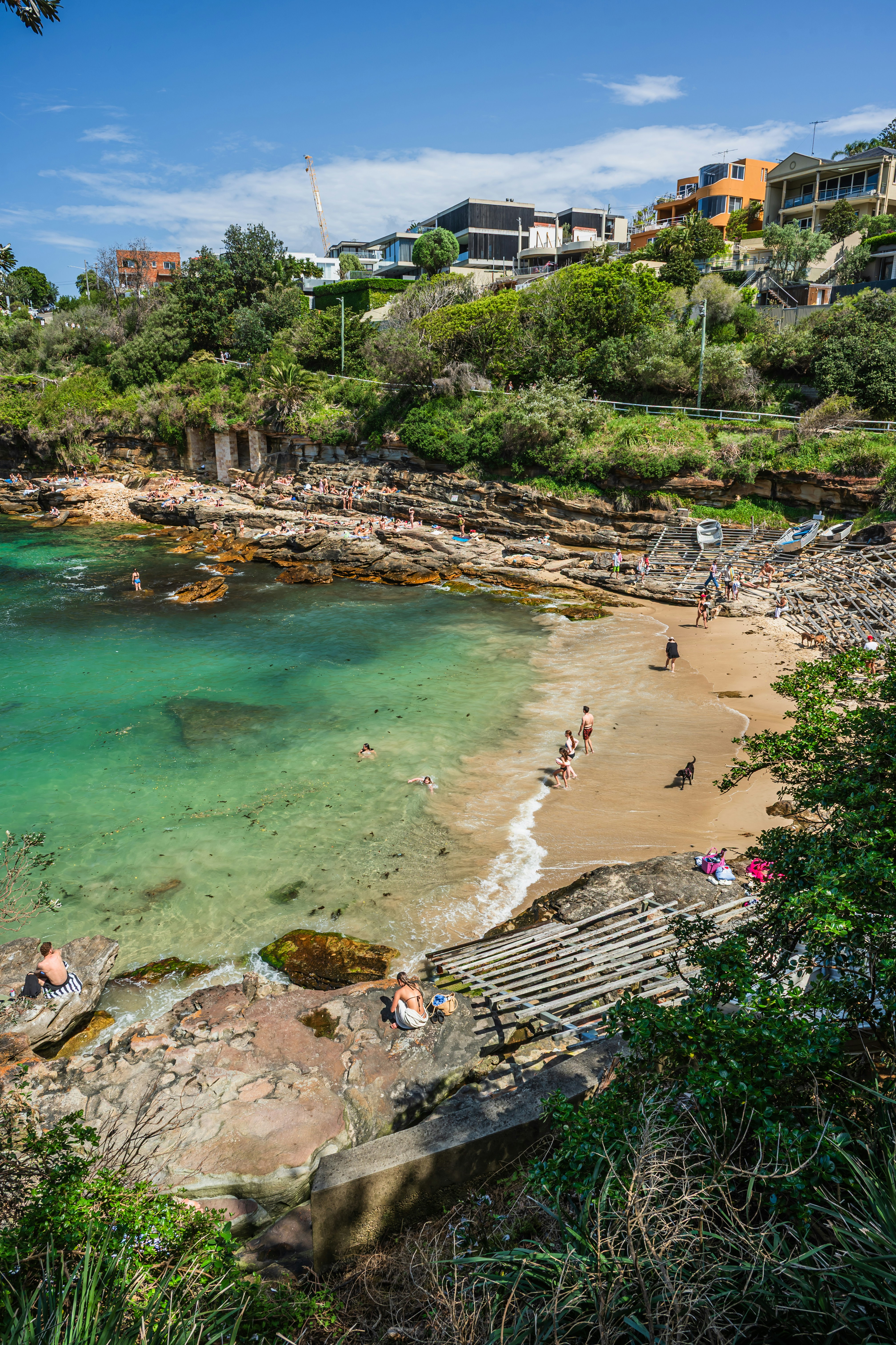 Sunlit Cove: A Scenic Coastal Village Beach with Terraced Rocks and Bright Aerial Color