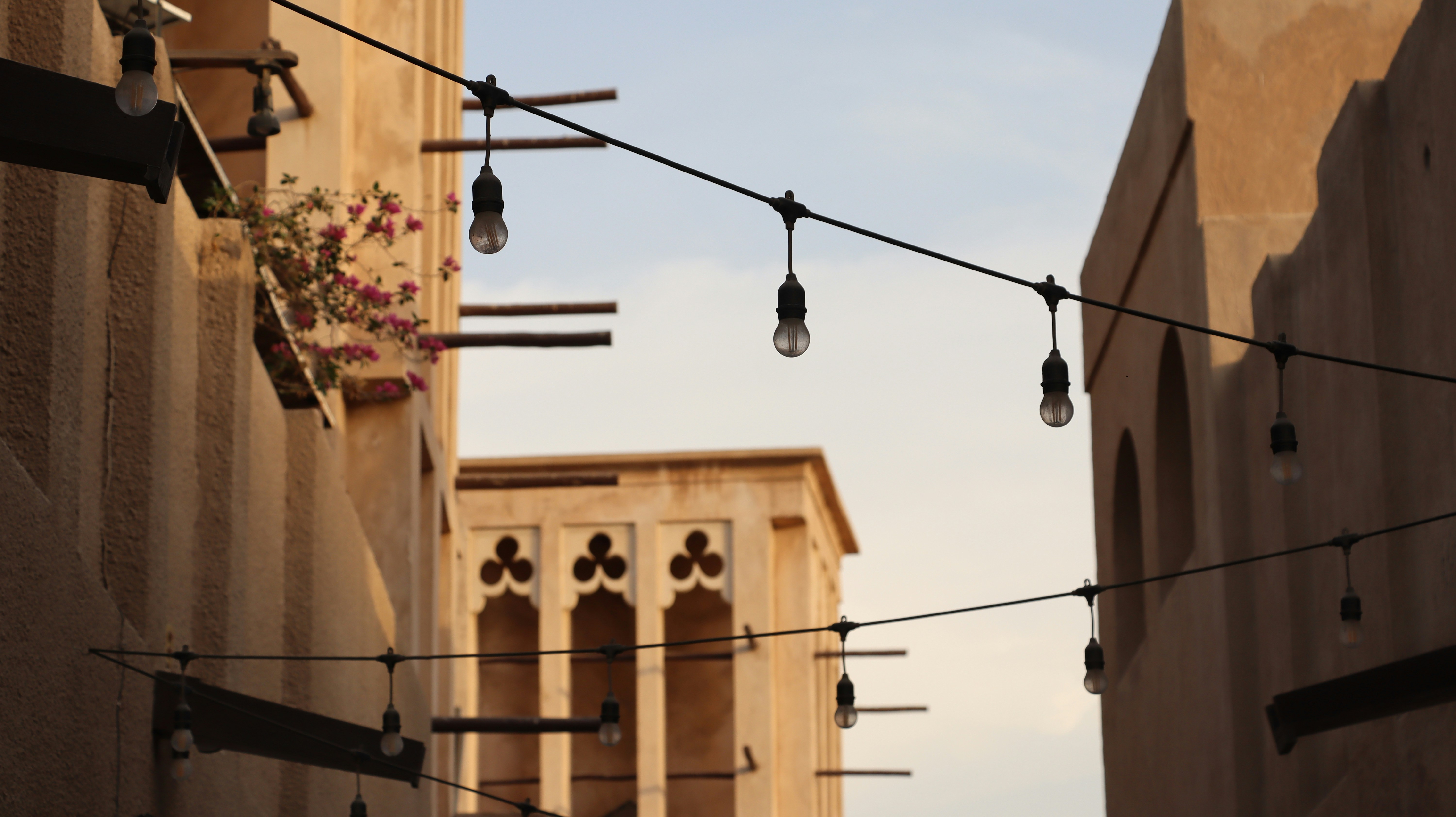 String lights hang between buildings with ornate windows.