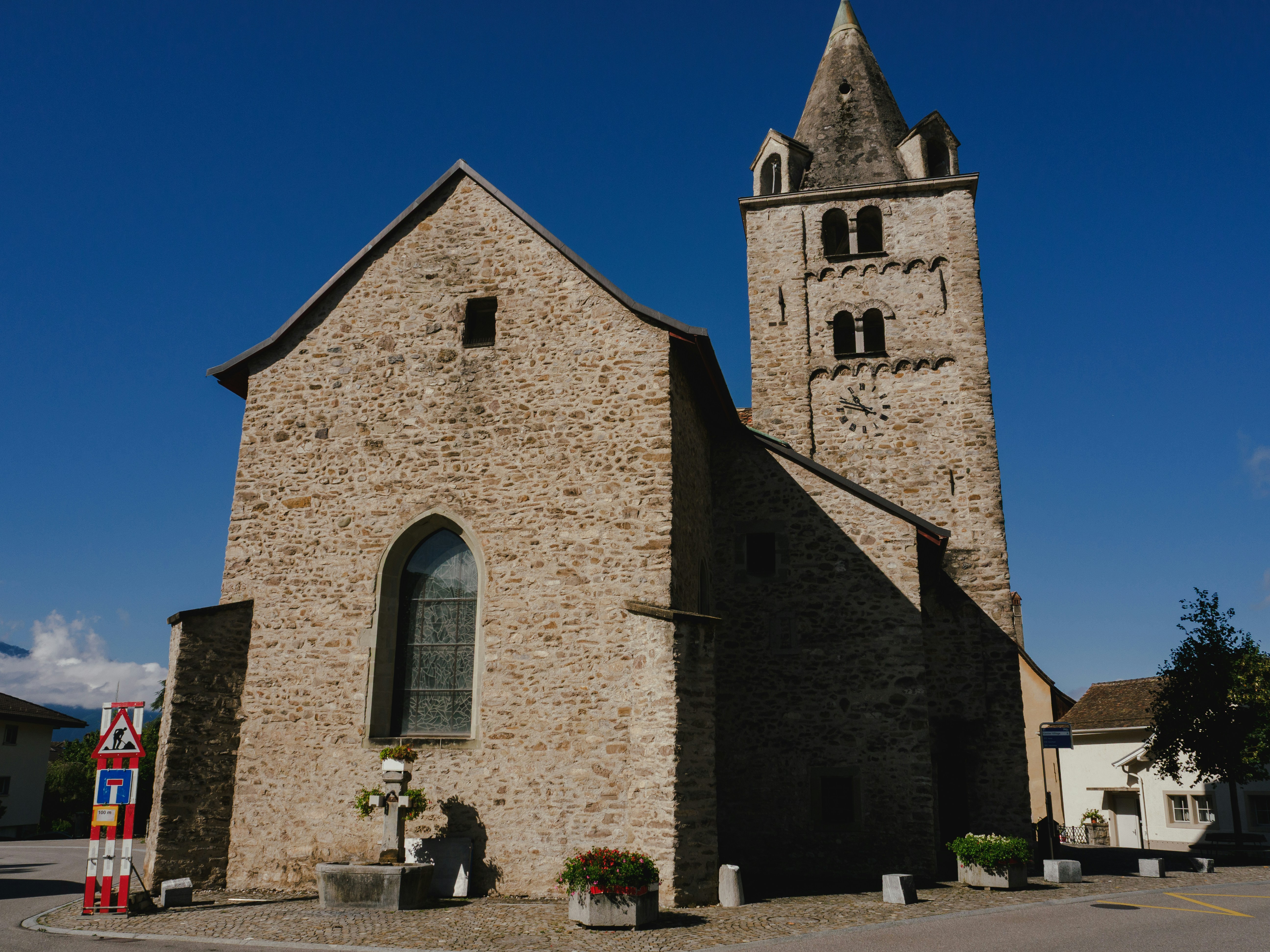 Church in Vevey, Switzerland | Stone church with a tall bell tower under blue sky.