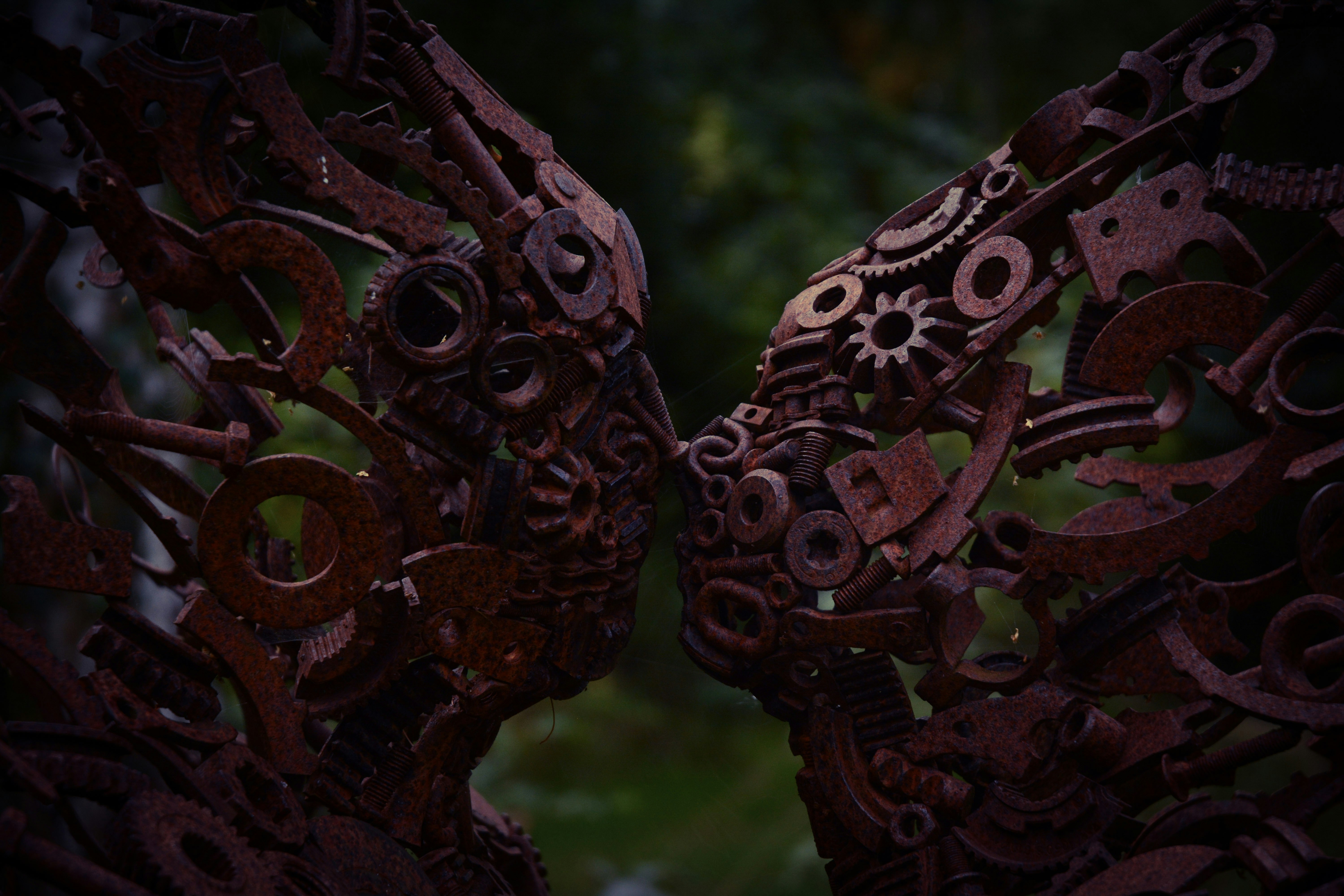 Two rusty metal bird sculptures kissing