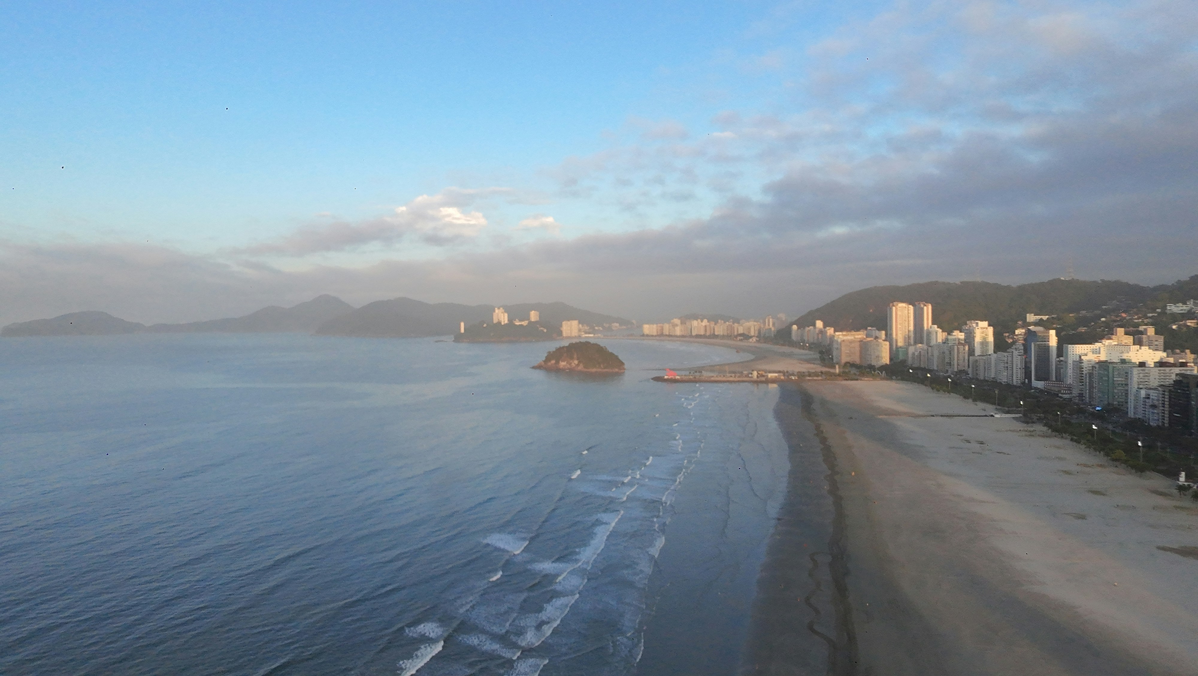 Coastal city skyline with a beach and ocean.