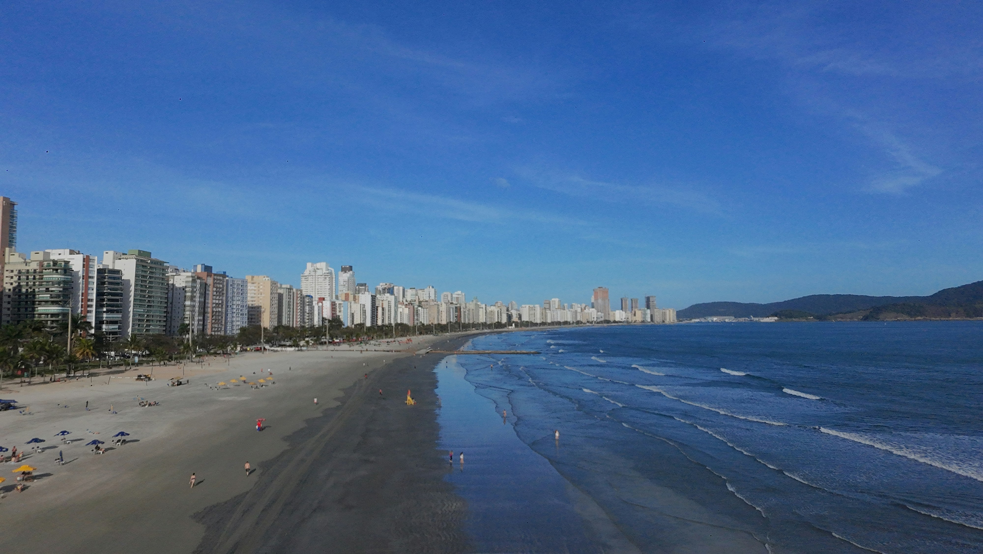 Coastal cityscape with a long sandy beach and ocean.