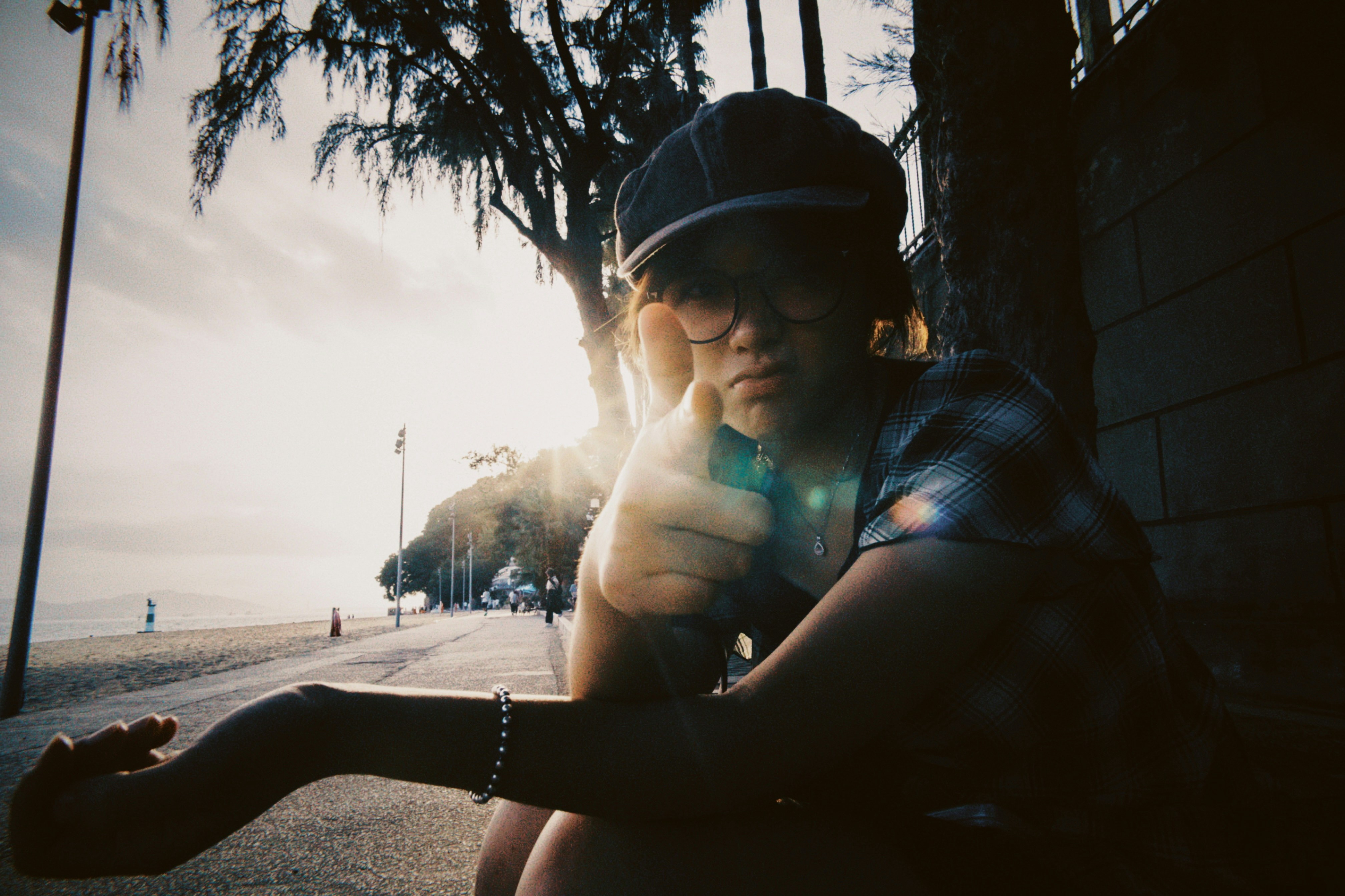 Sunset Gaze: A Shadowed Portrait on a Palm-Lined Beach Path