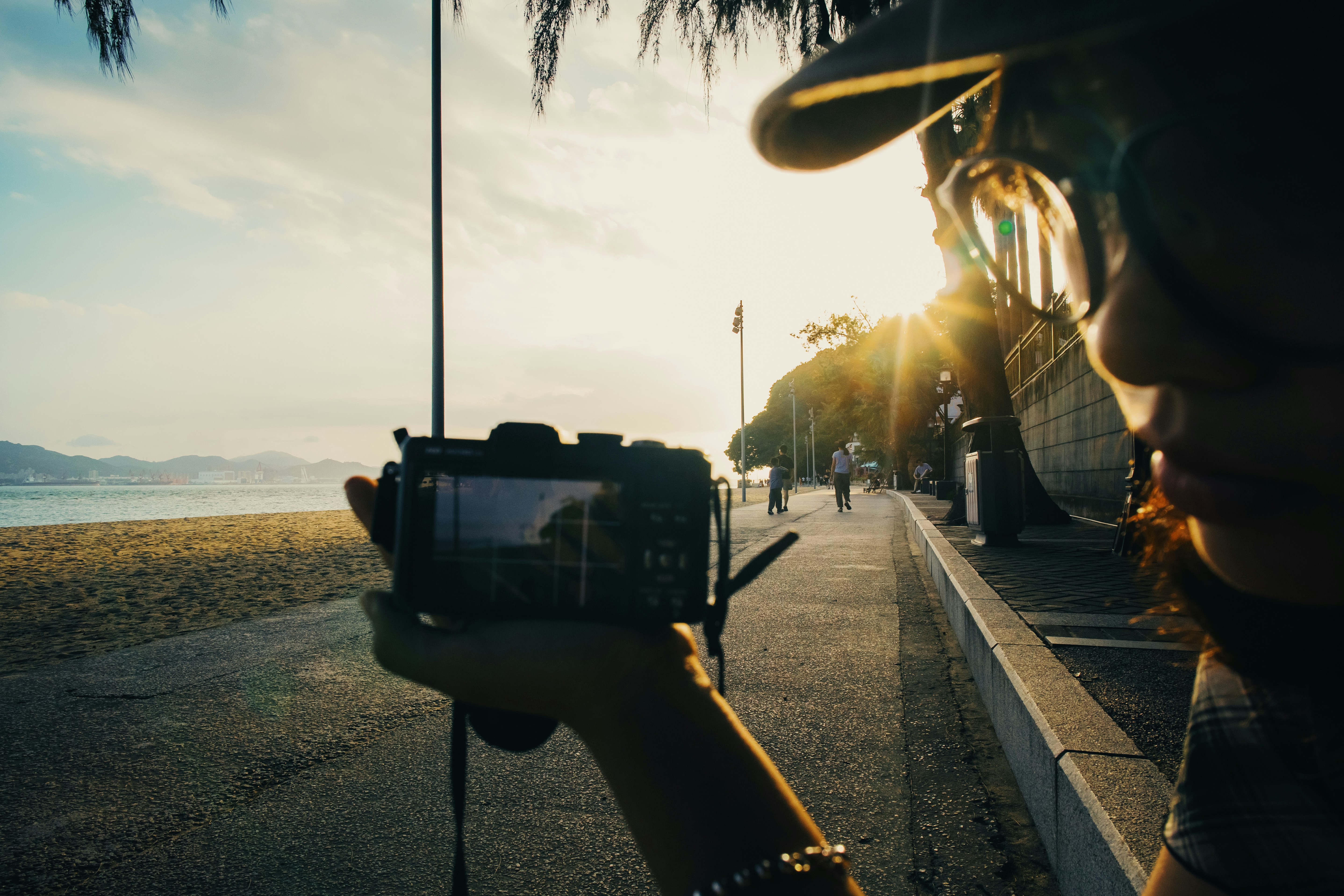 Backlit Promenade: Framing a Coastal Sunset Through a Handheld Camera