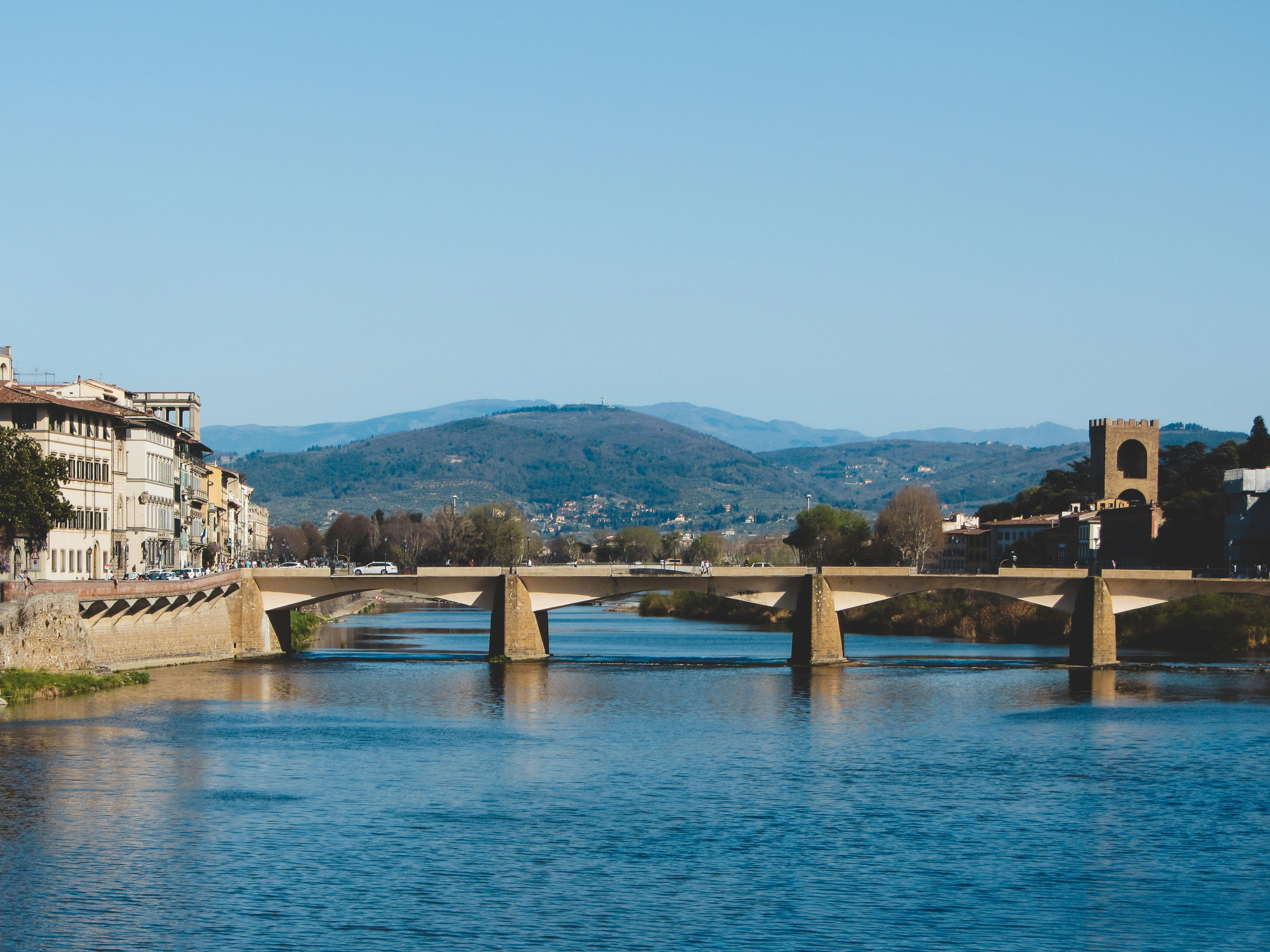 Ponte alle Grazie | Bridge over a wide river with buildings and hills.