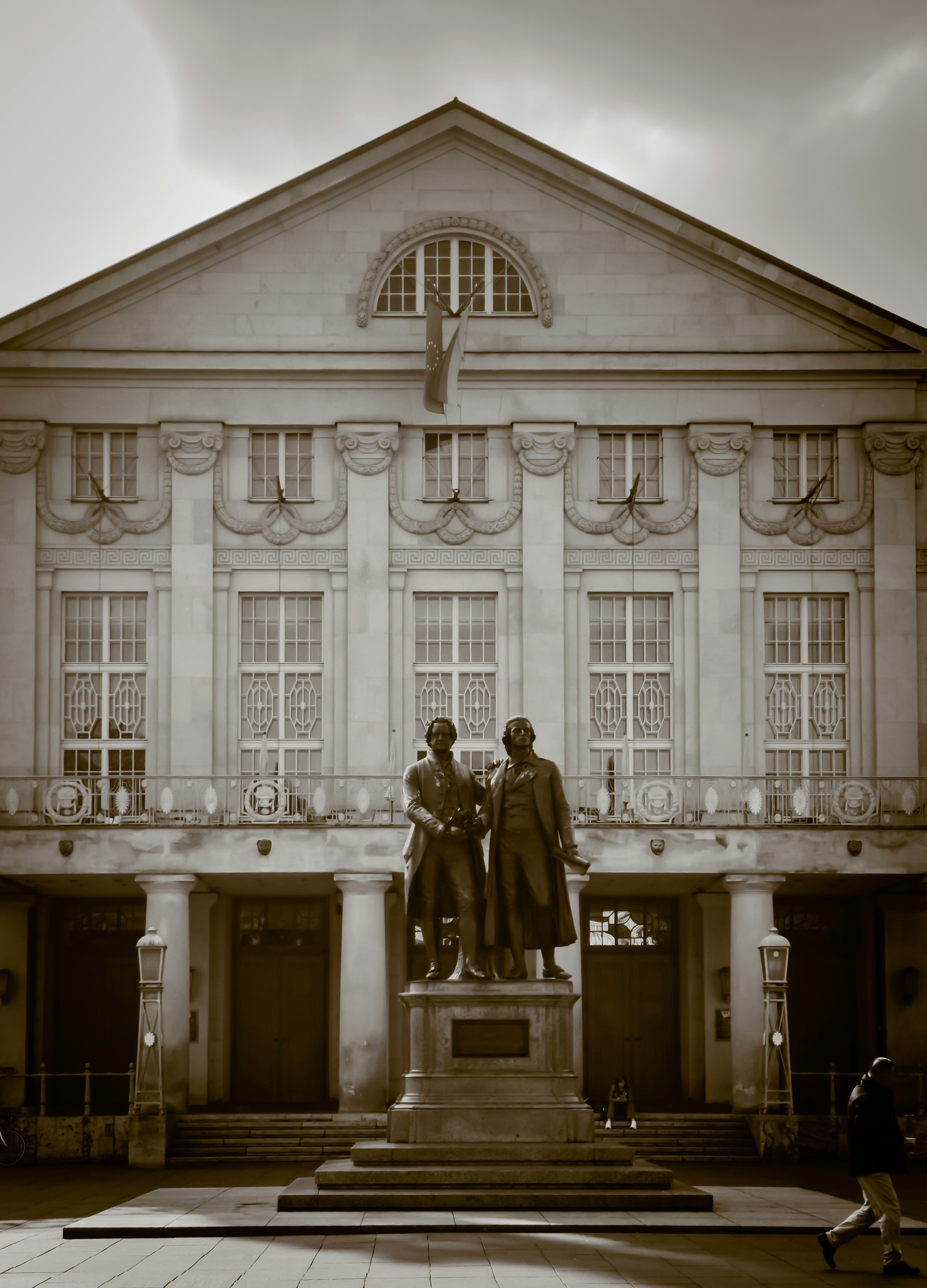 Statue of two men in front of classical building