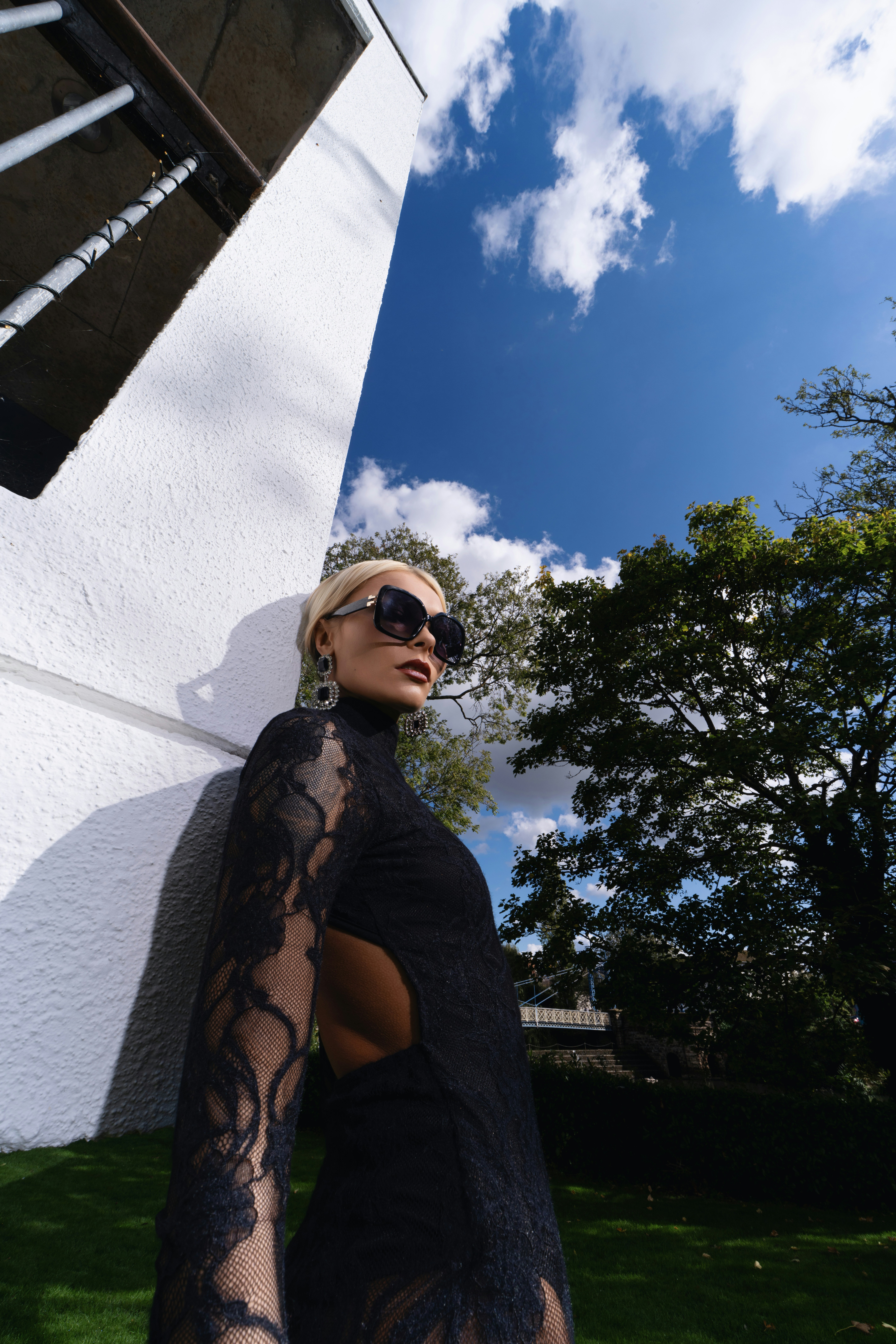 Lace Under a Skyward Gaze: Portrait by the White Facade