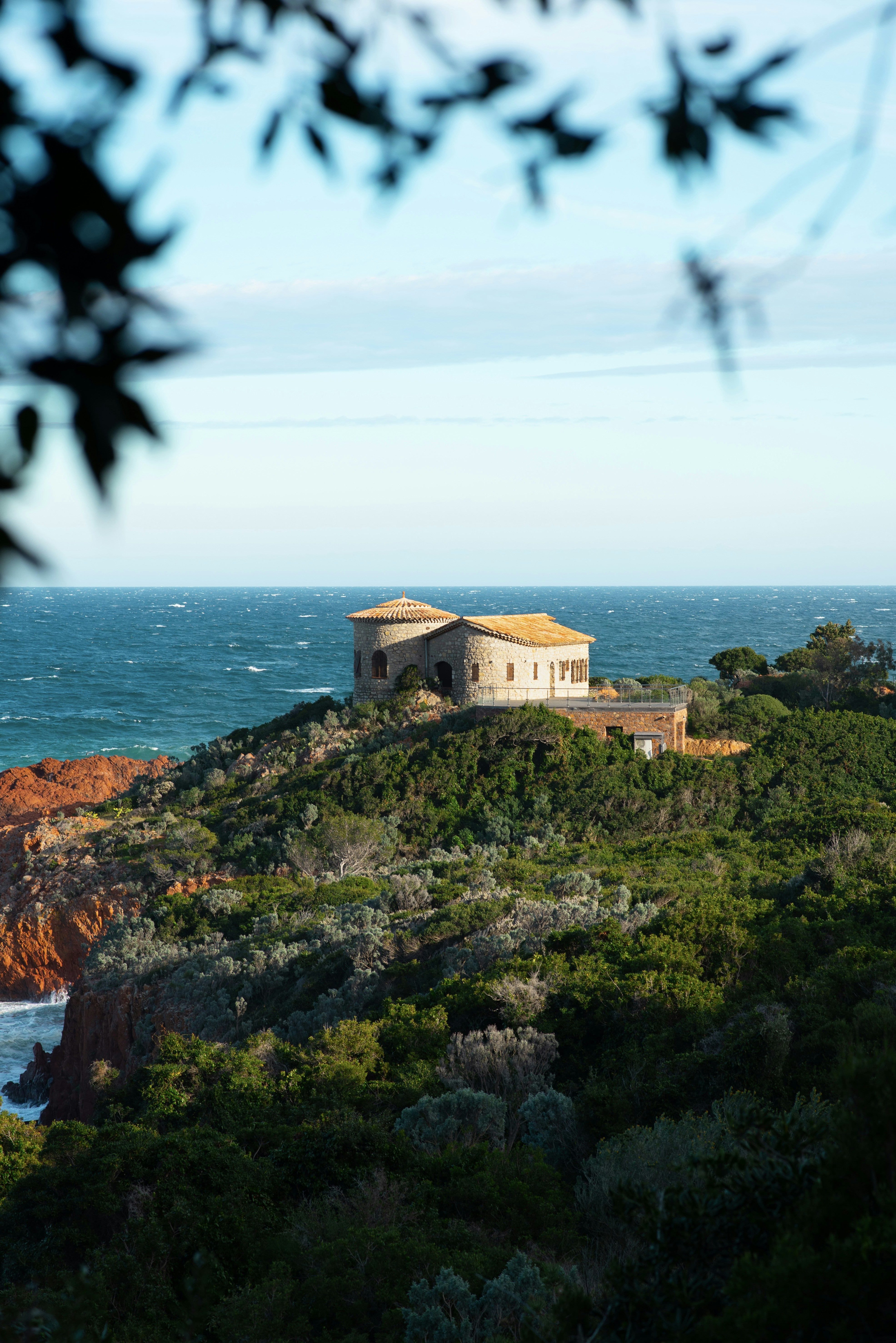 House on a green cliff overlooking the ocean.