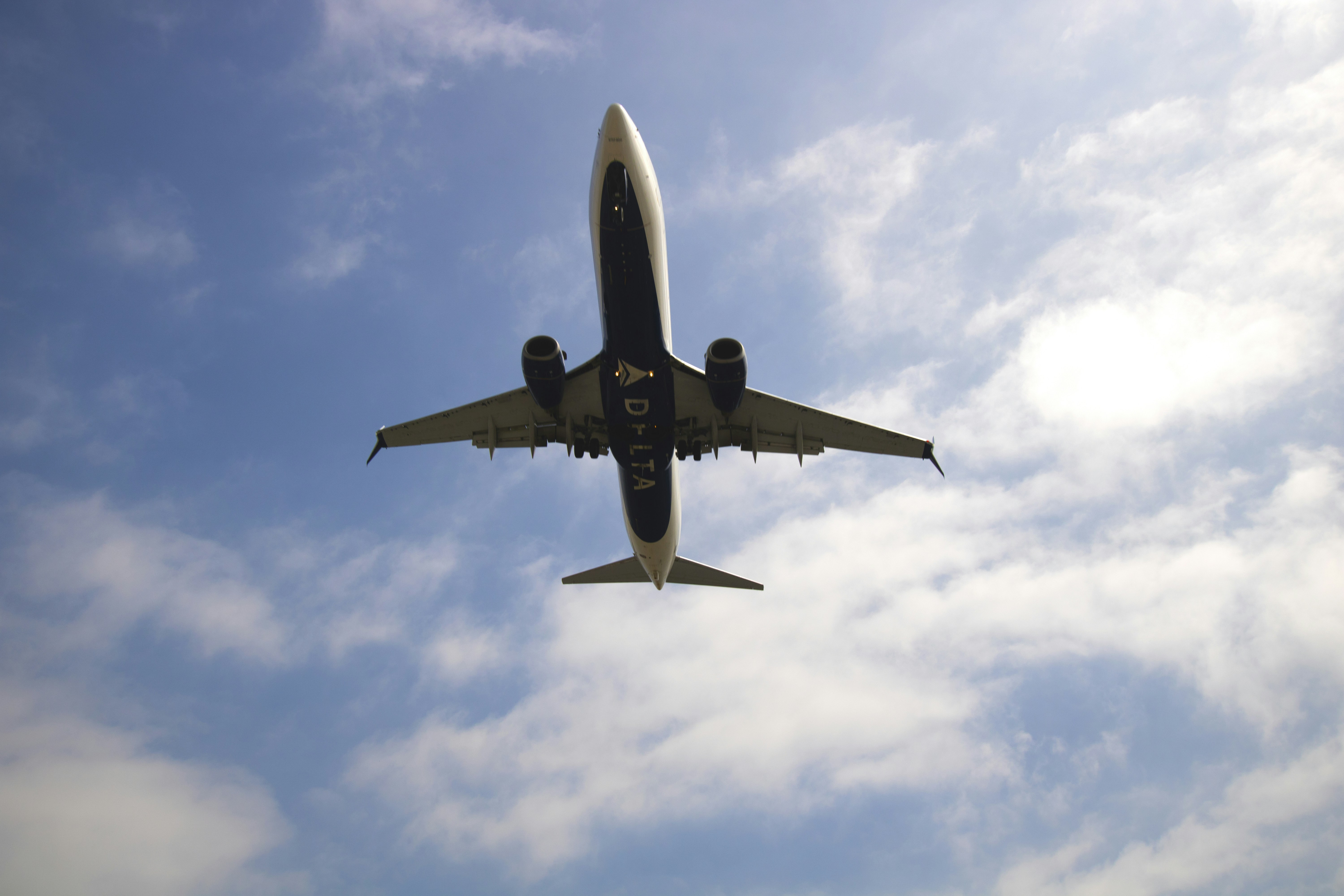 Airplane flying in a cloudy blue sky.
