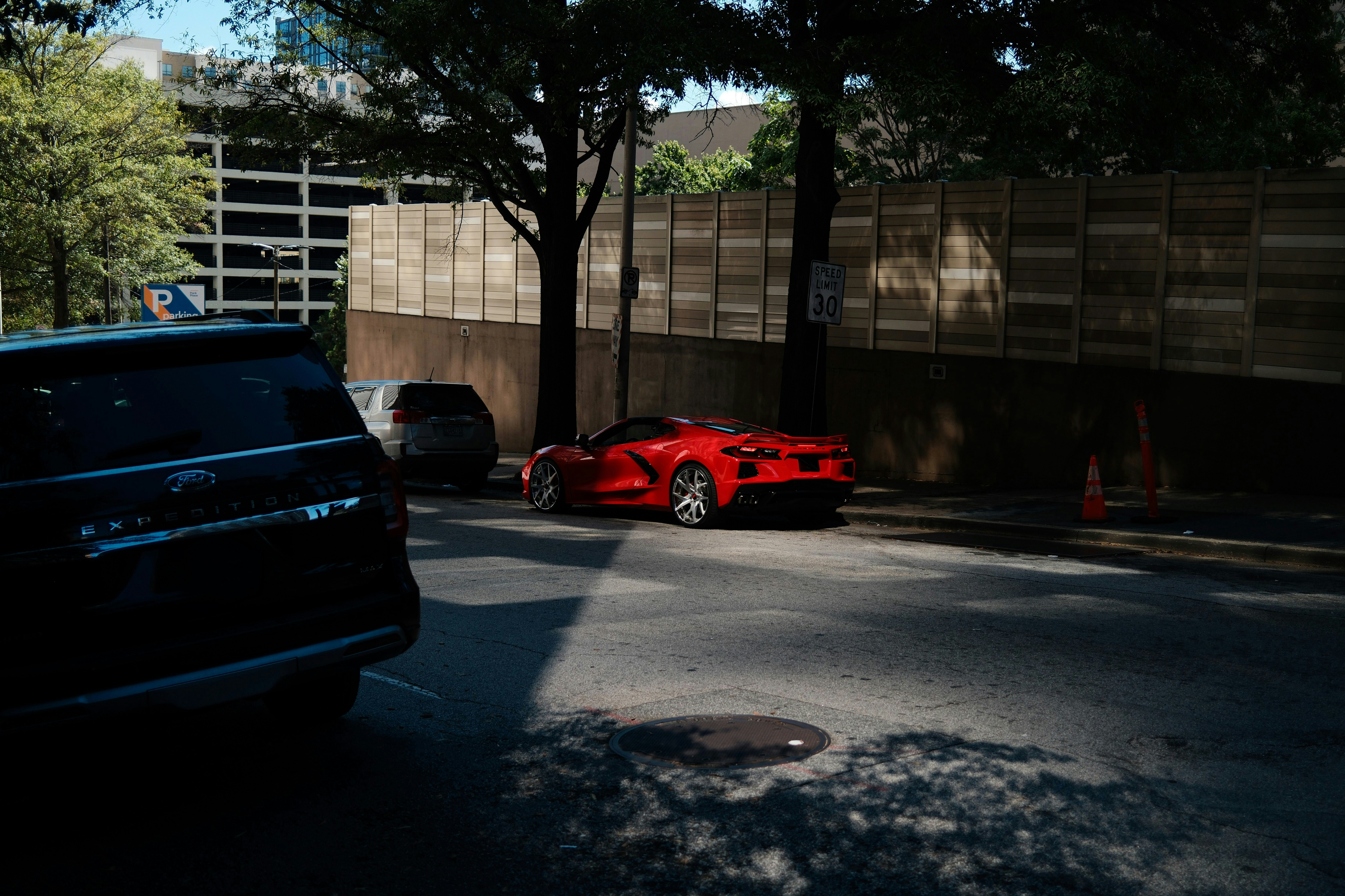 Urban Elegance: A Red Corvette Amidst City Shadows