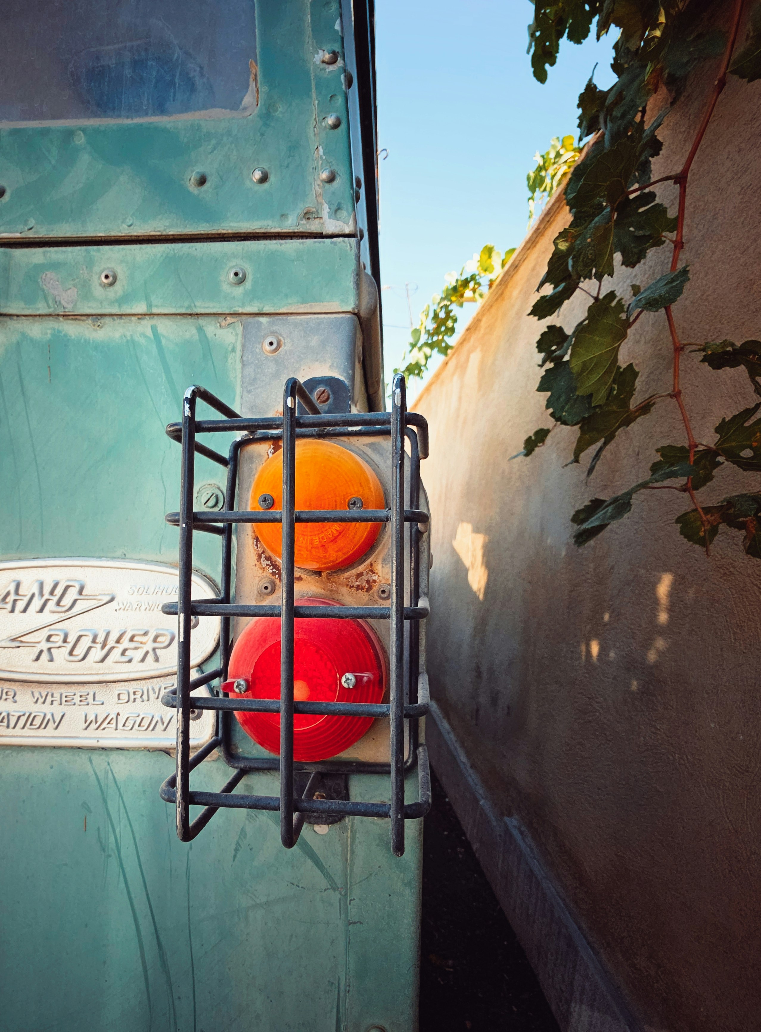 Old green land rover with protective light guards.