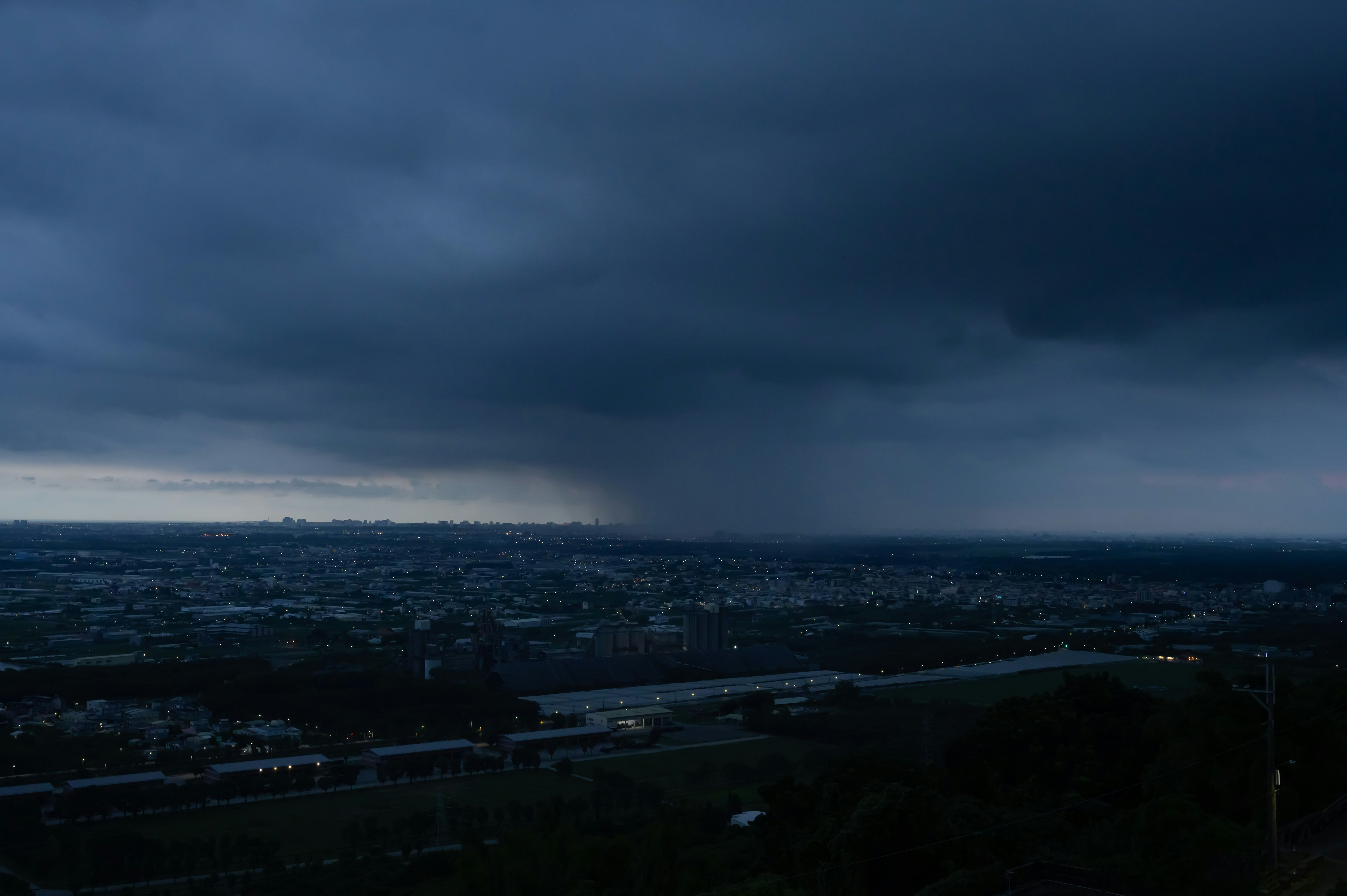 Dark storm clouds gather over a city skyline.
