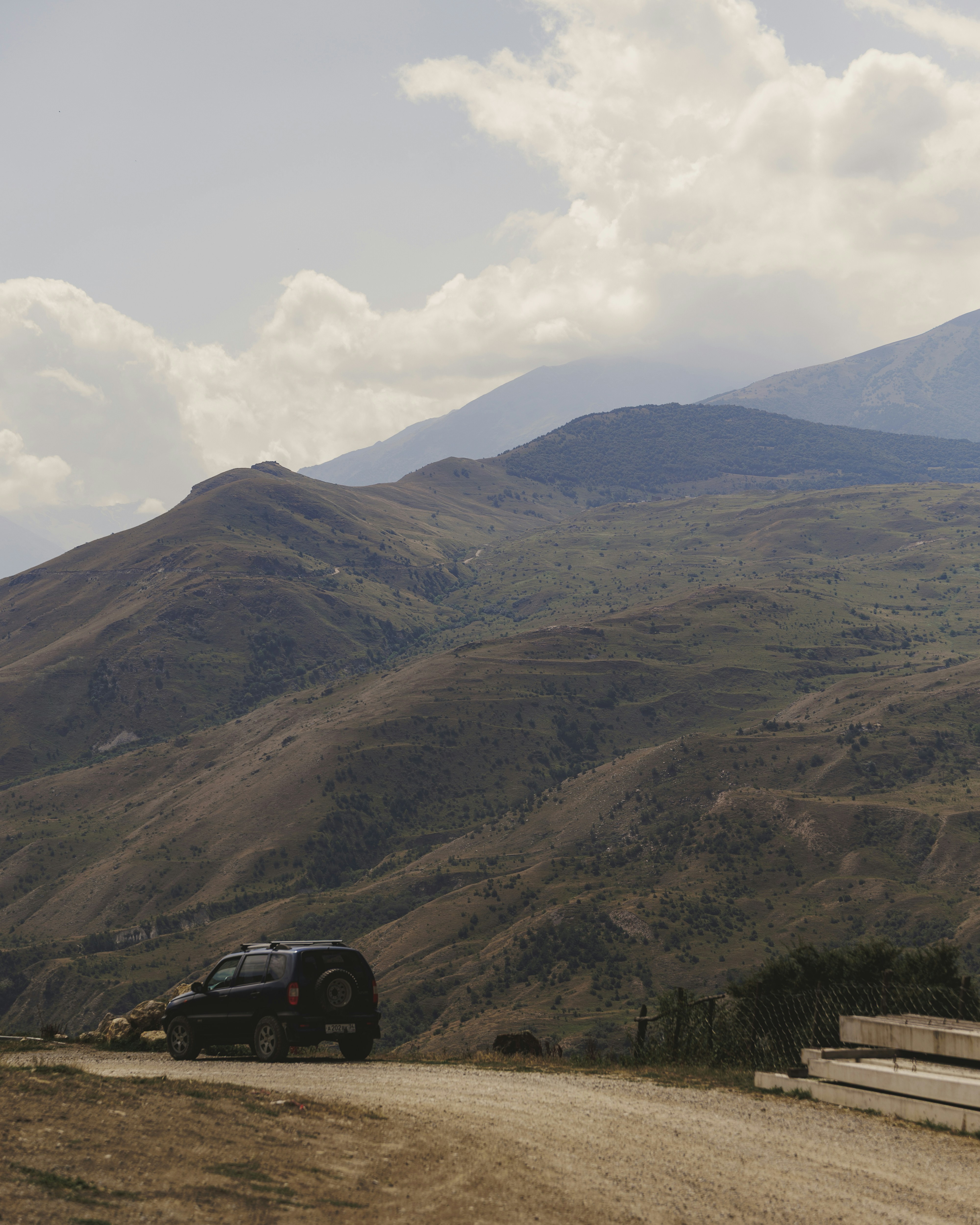 tg - @Fearvii inst - @m8tito | Black suv parked on a dirt road with mountains behind.