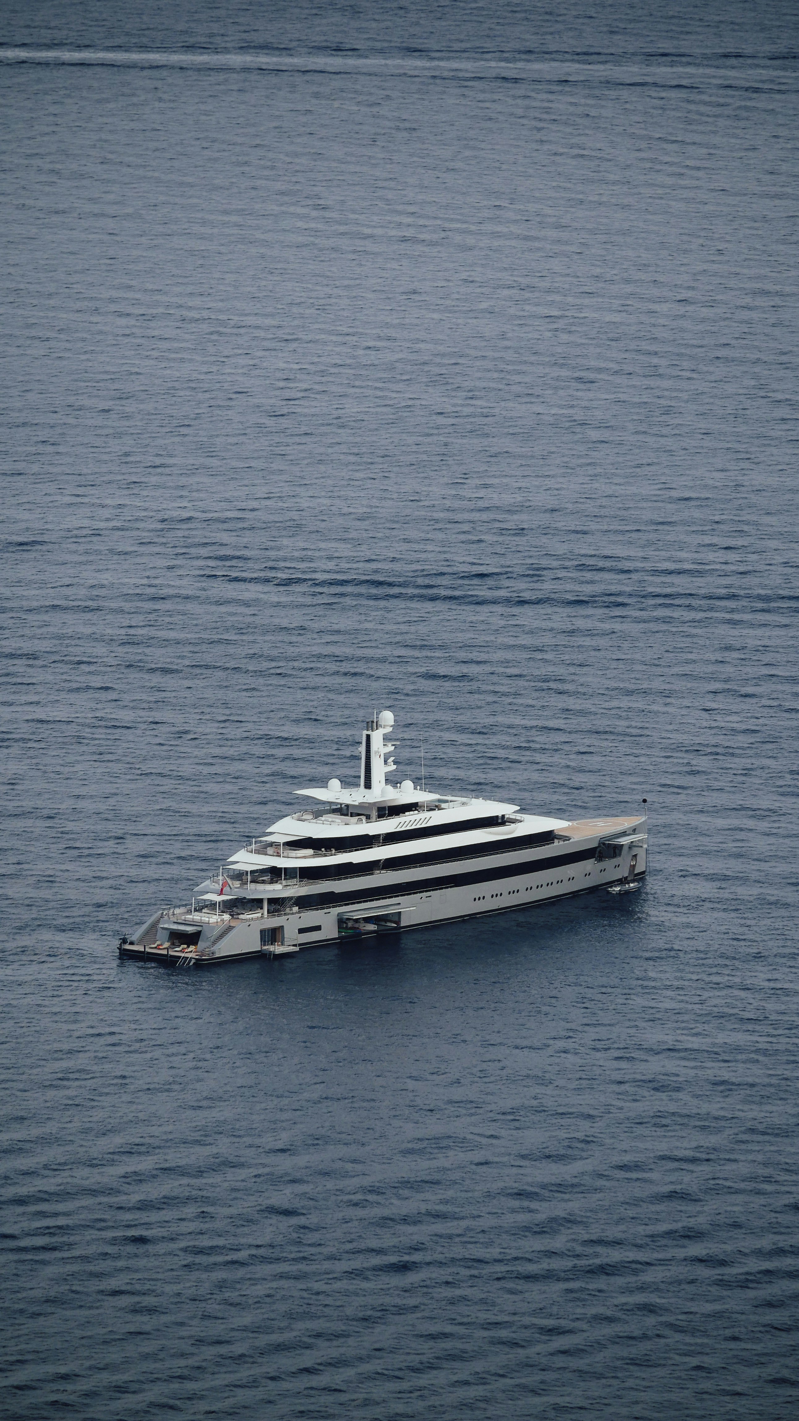 A sleek yacht floating serenely on calm ocean waters, showcasing modern design and elegance.
