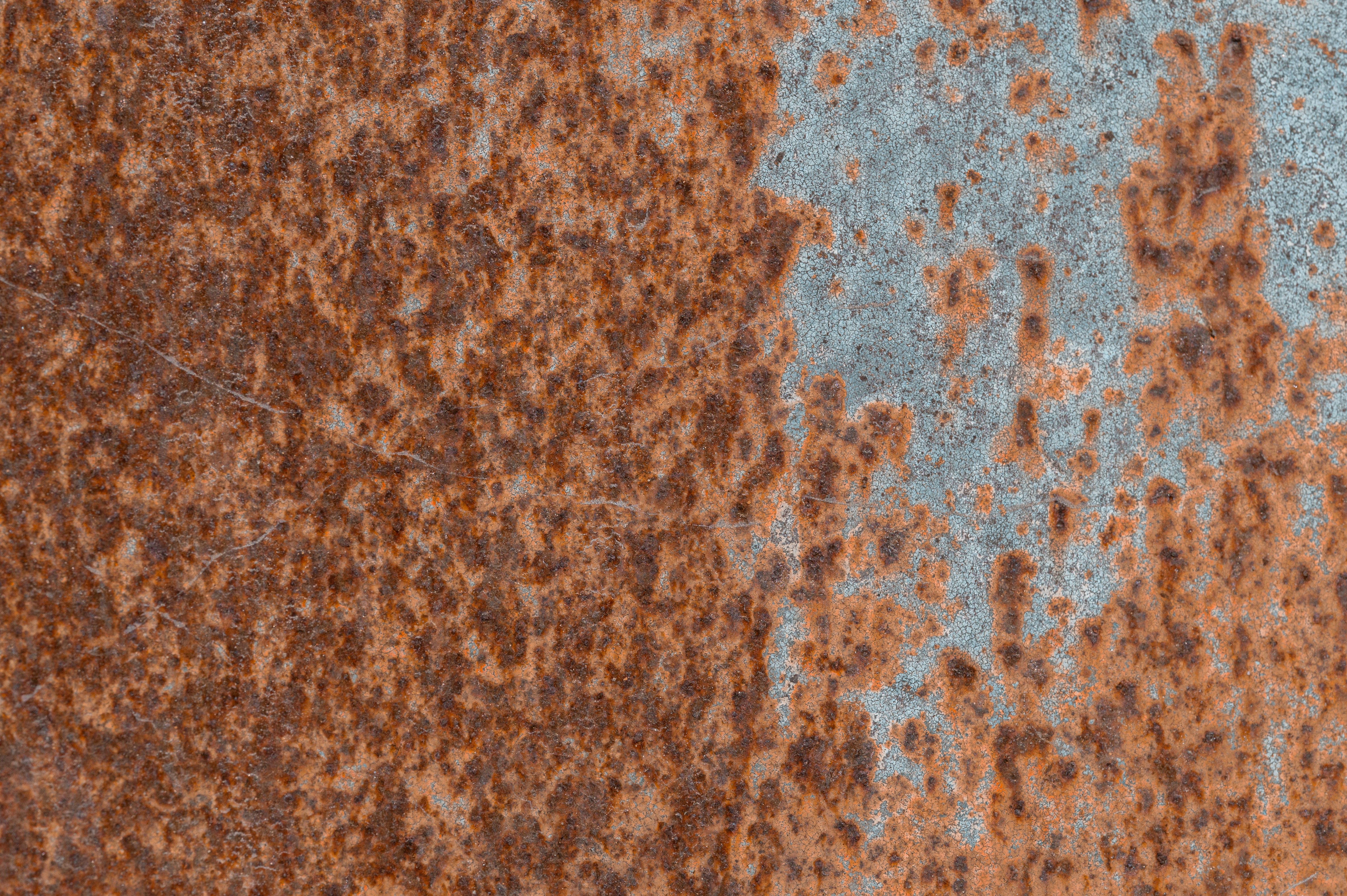 Close-up of textured rusty metal surface with gray patches