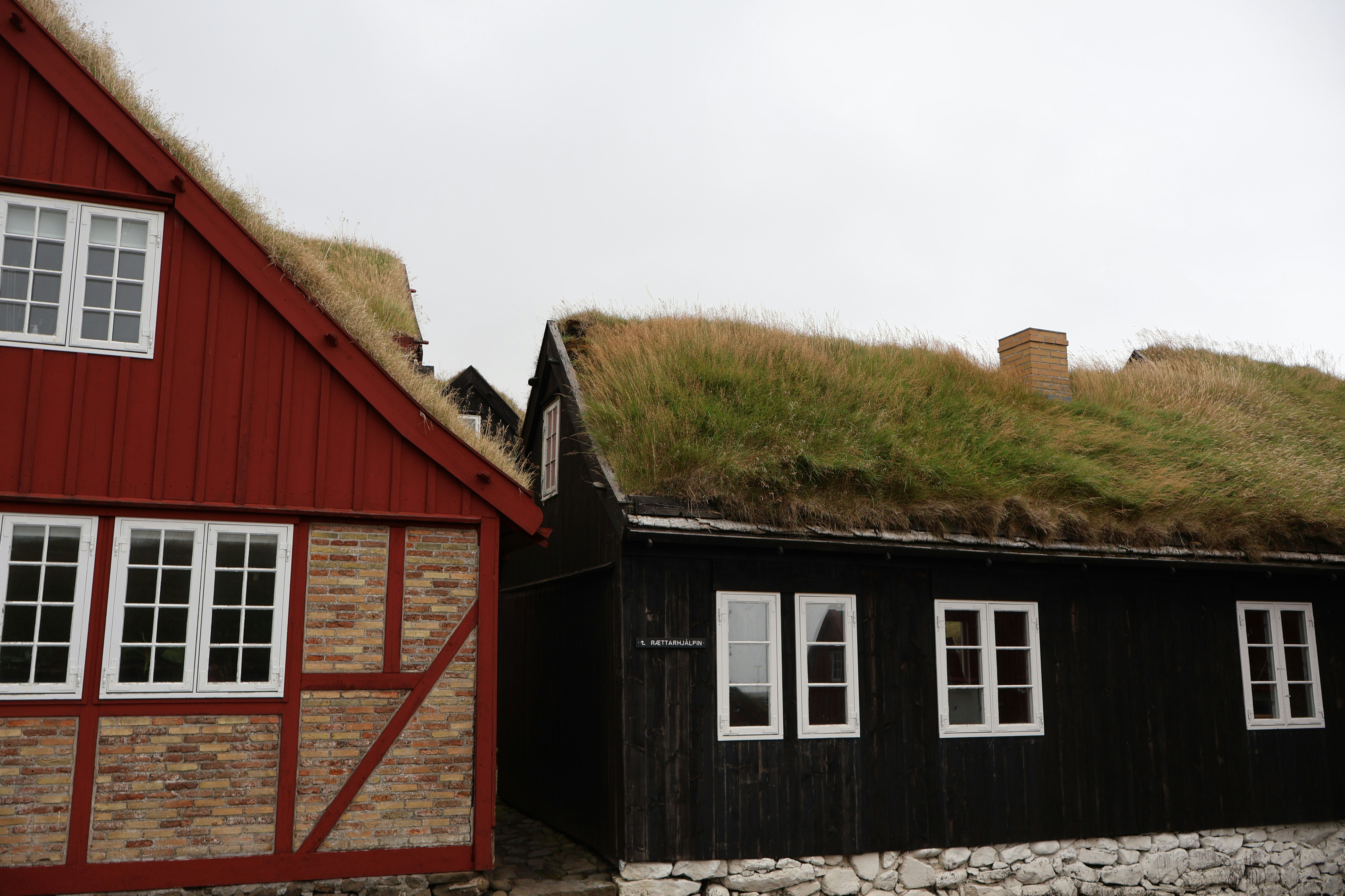 Traditional houses with grass roofs under cloudy sky