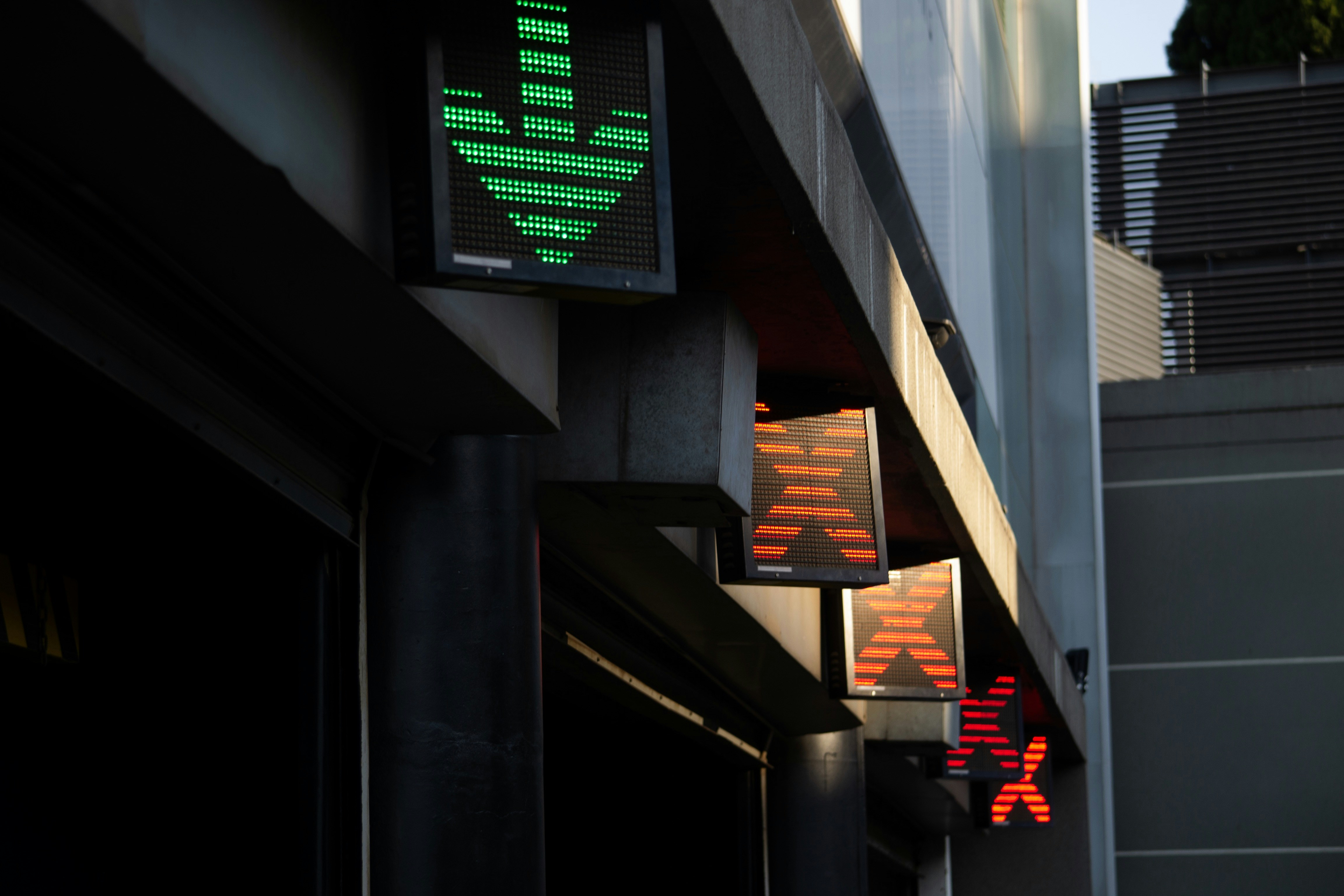 Neon Arrows on a Dim Facade: A Row of Urban Signage