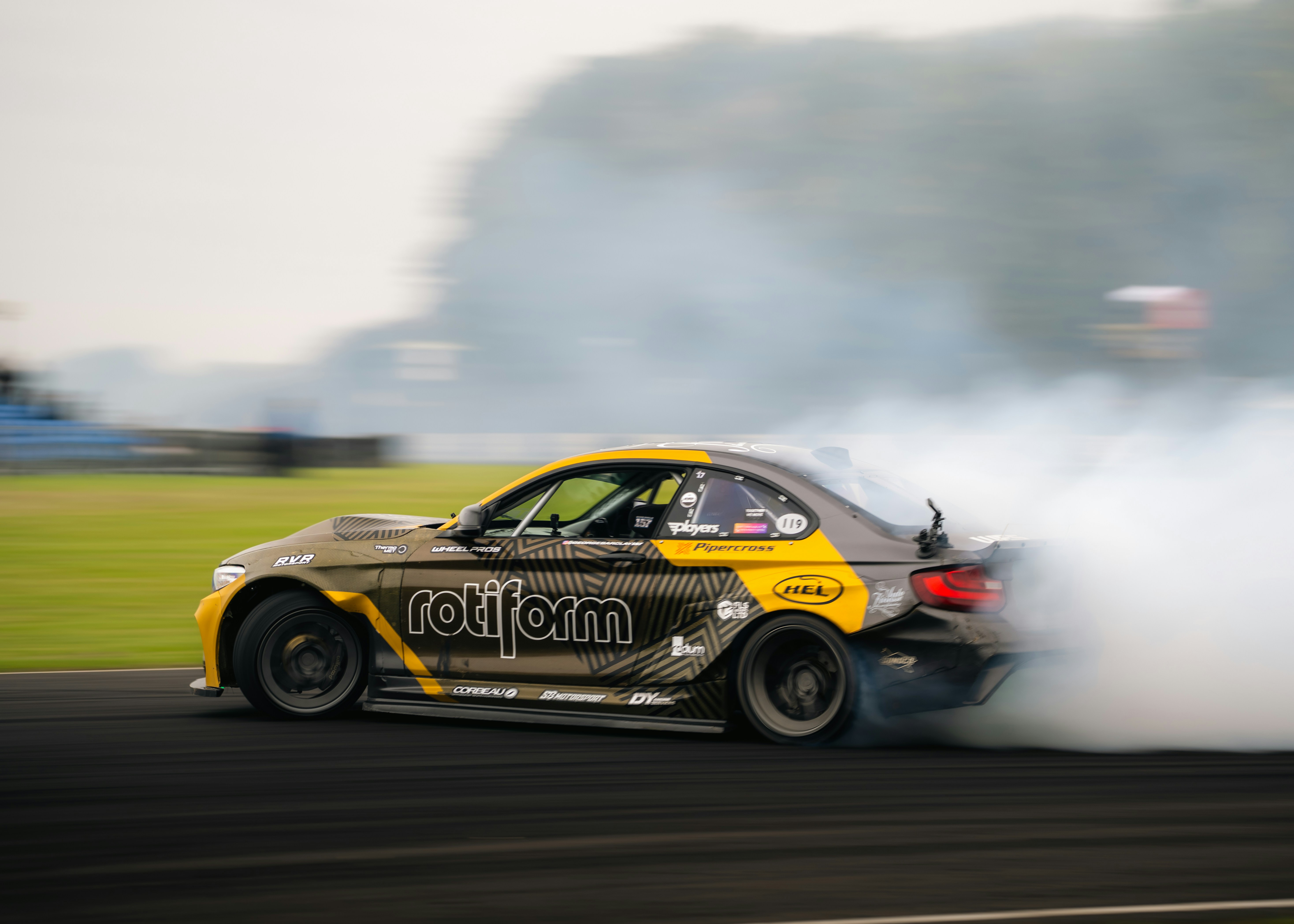 Drifting race car emitting smoke on track