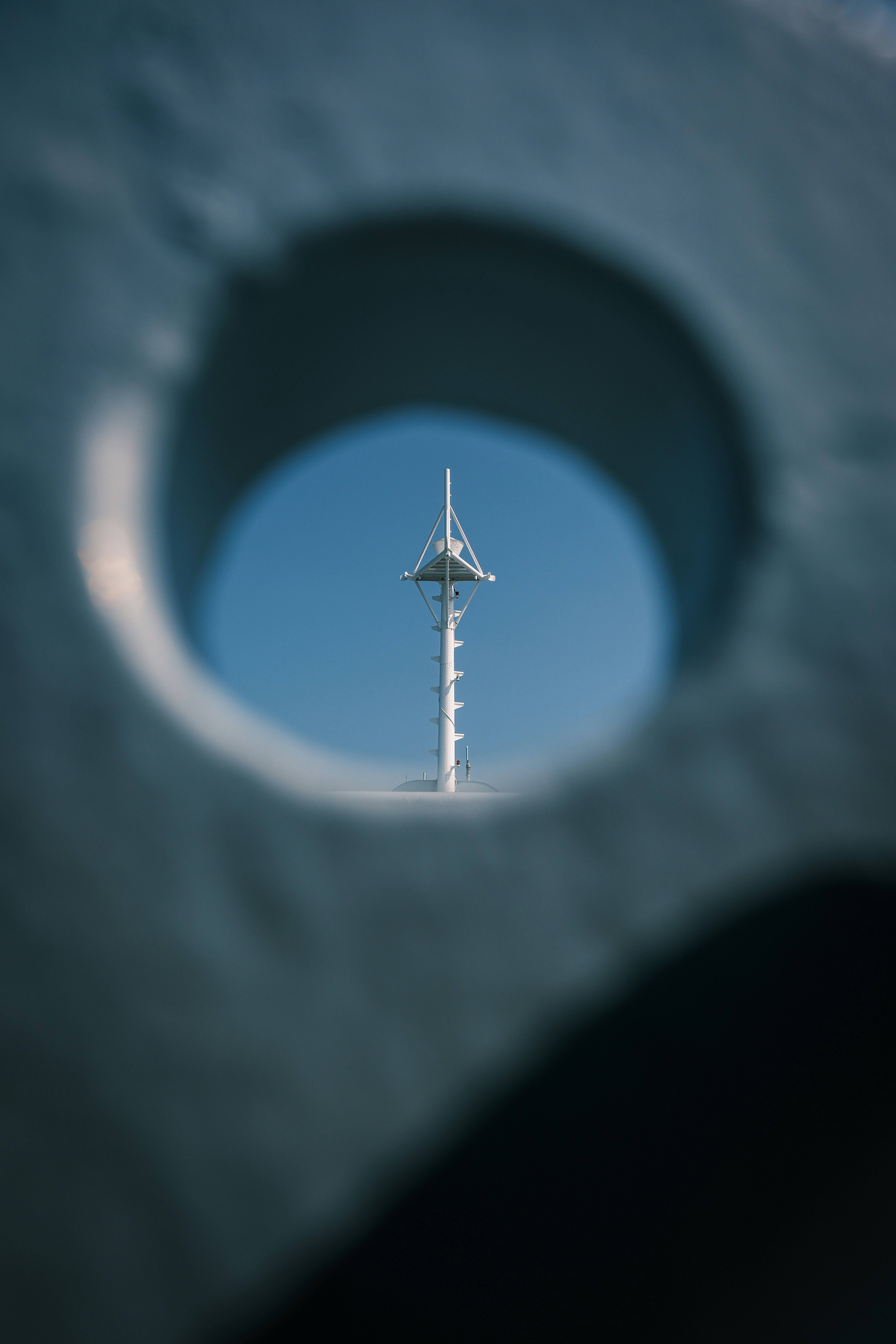 White tower seen through a circular opening