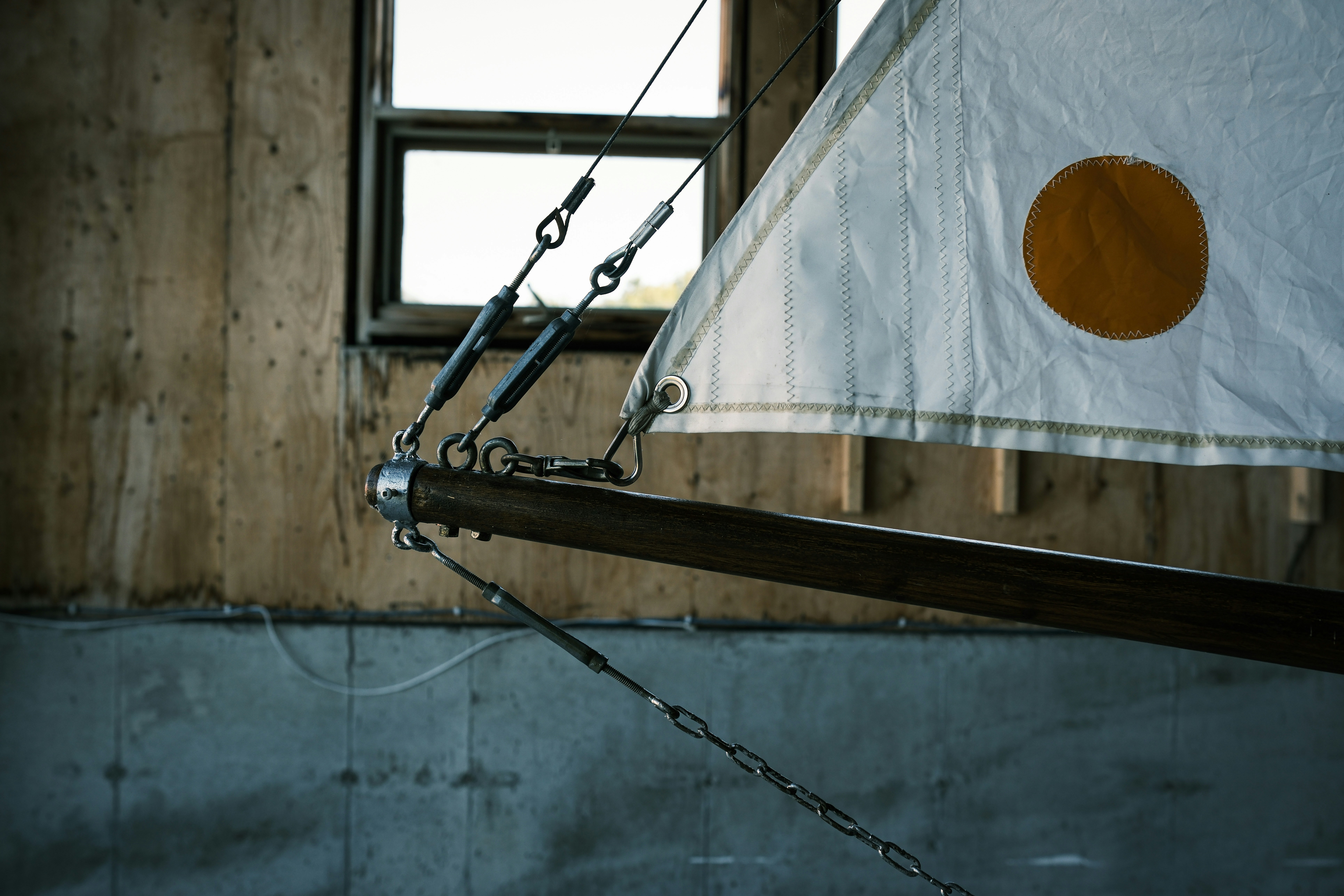 Sailboat mast and sail with orange circle emblem