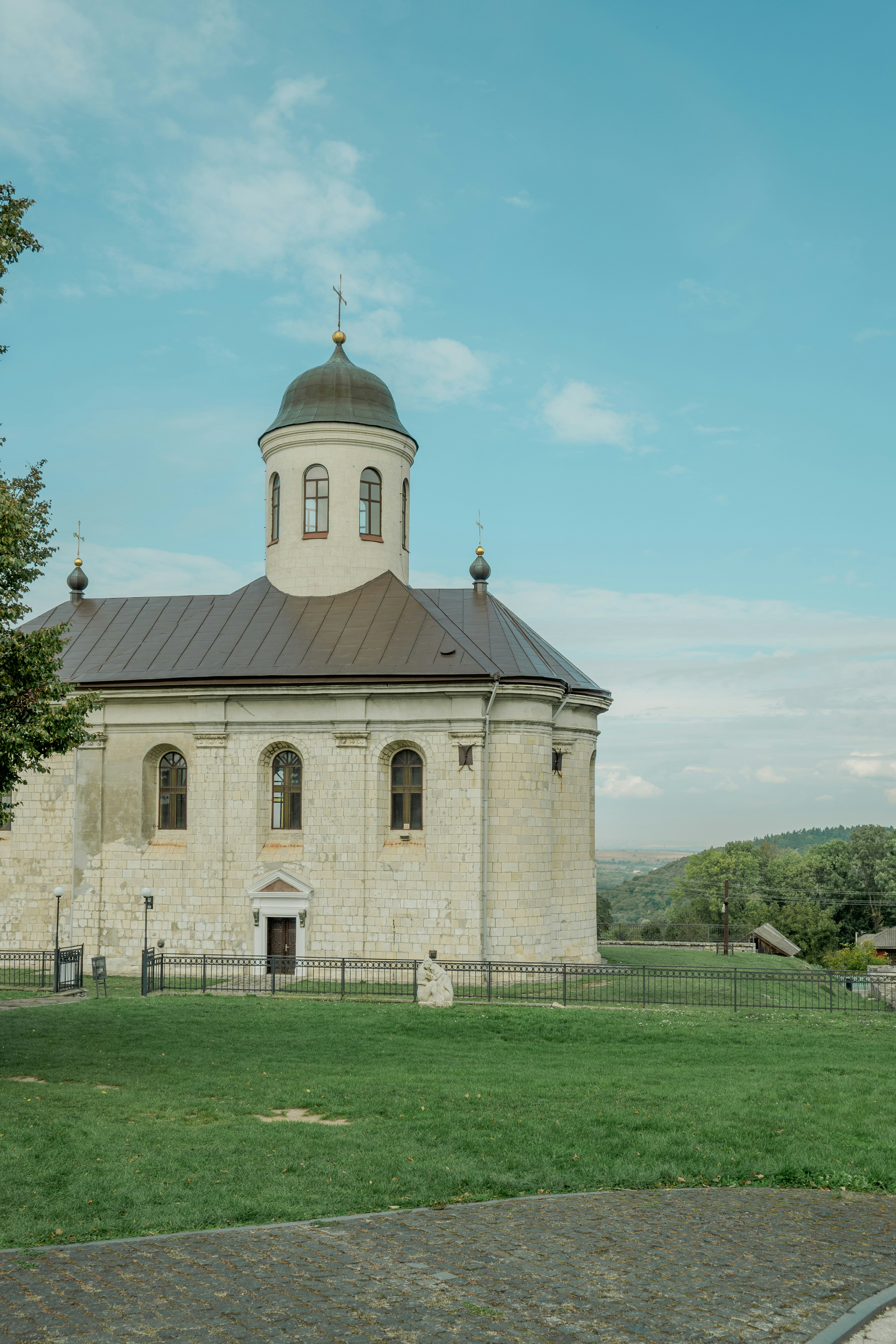 Stone church with a dome under a blue sky.