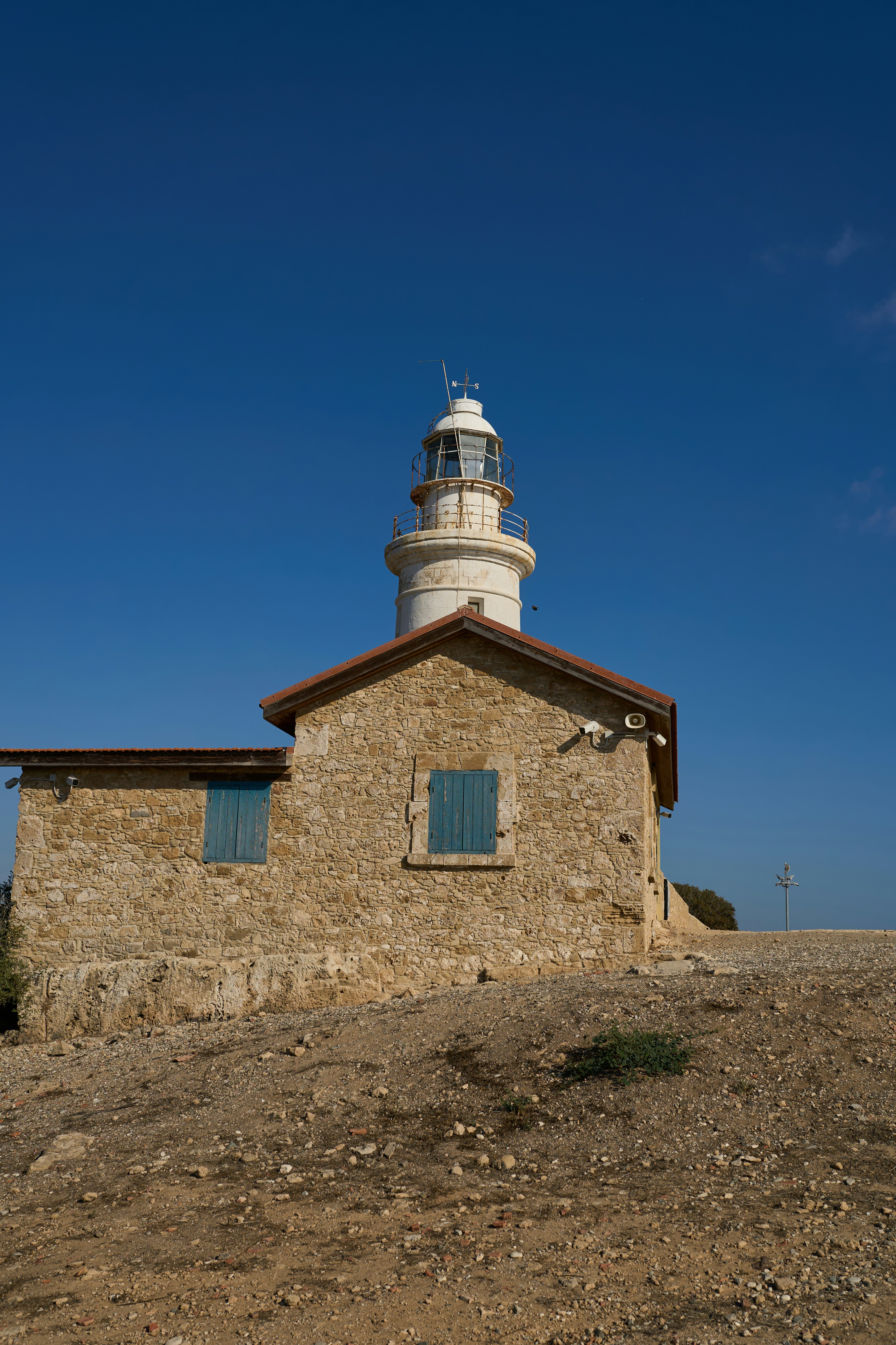 Stone lighthouse building under a clear blue sky.