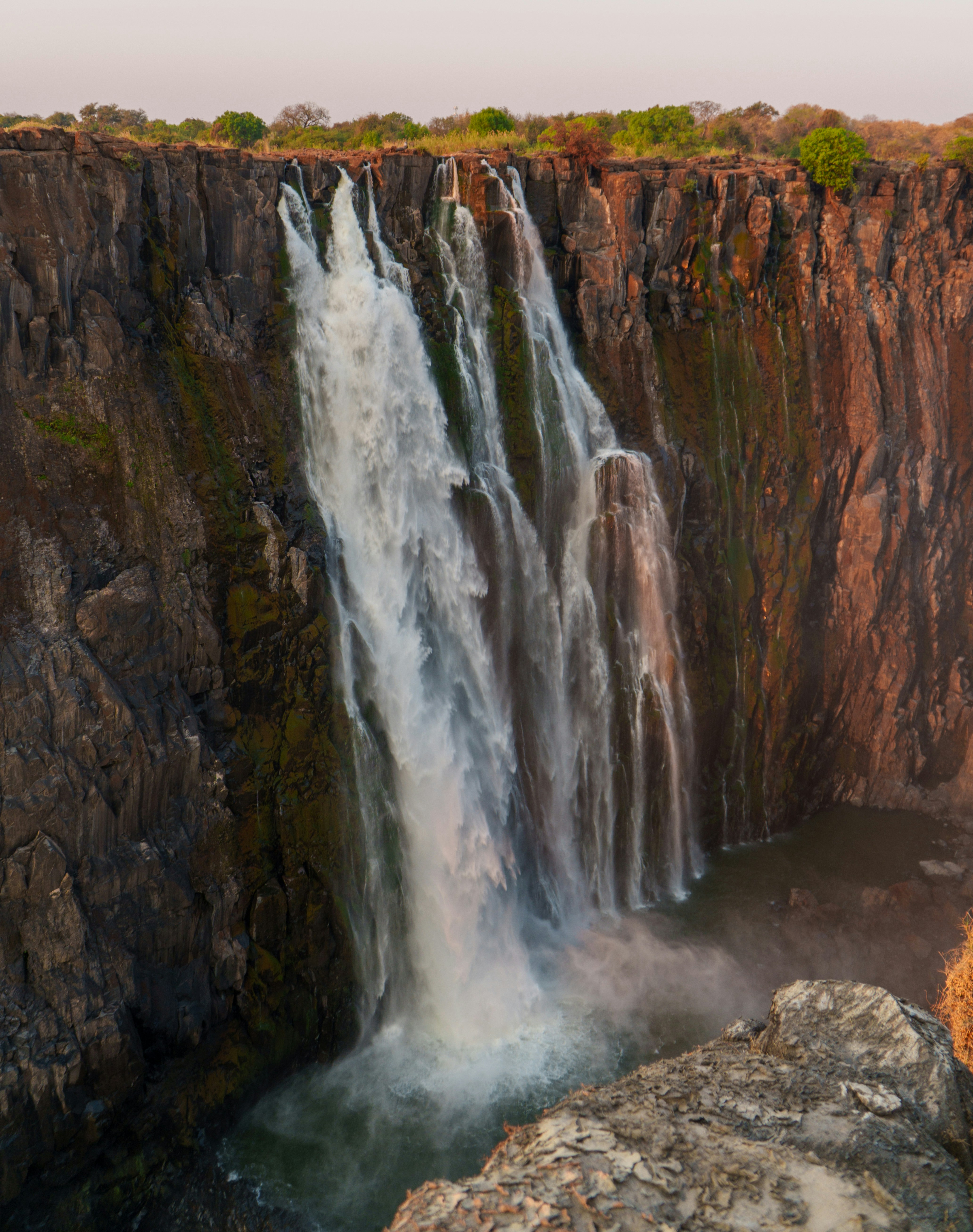 Crimson Cliff Cascade: Dawn Light on a Multi-Thread Waterfall