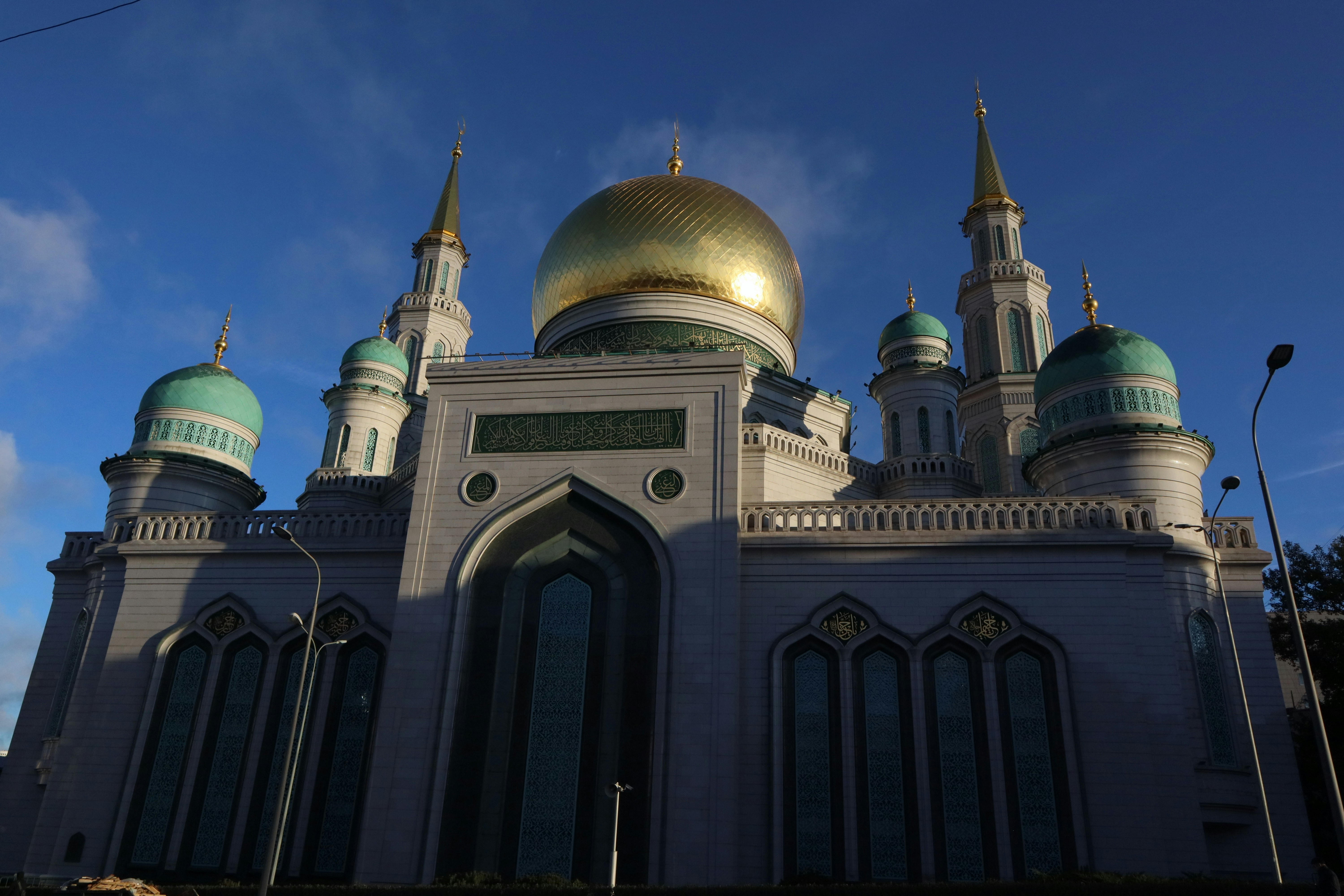 Gilded Crown Over Turquoise Minarets: Front View of a Majestic Mosque