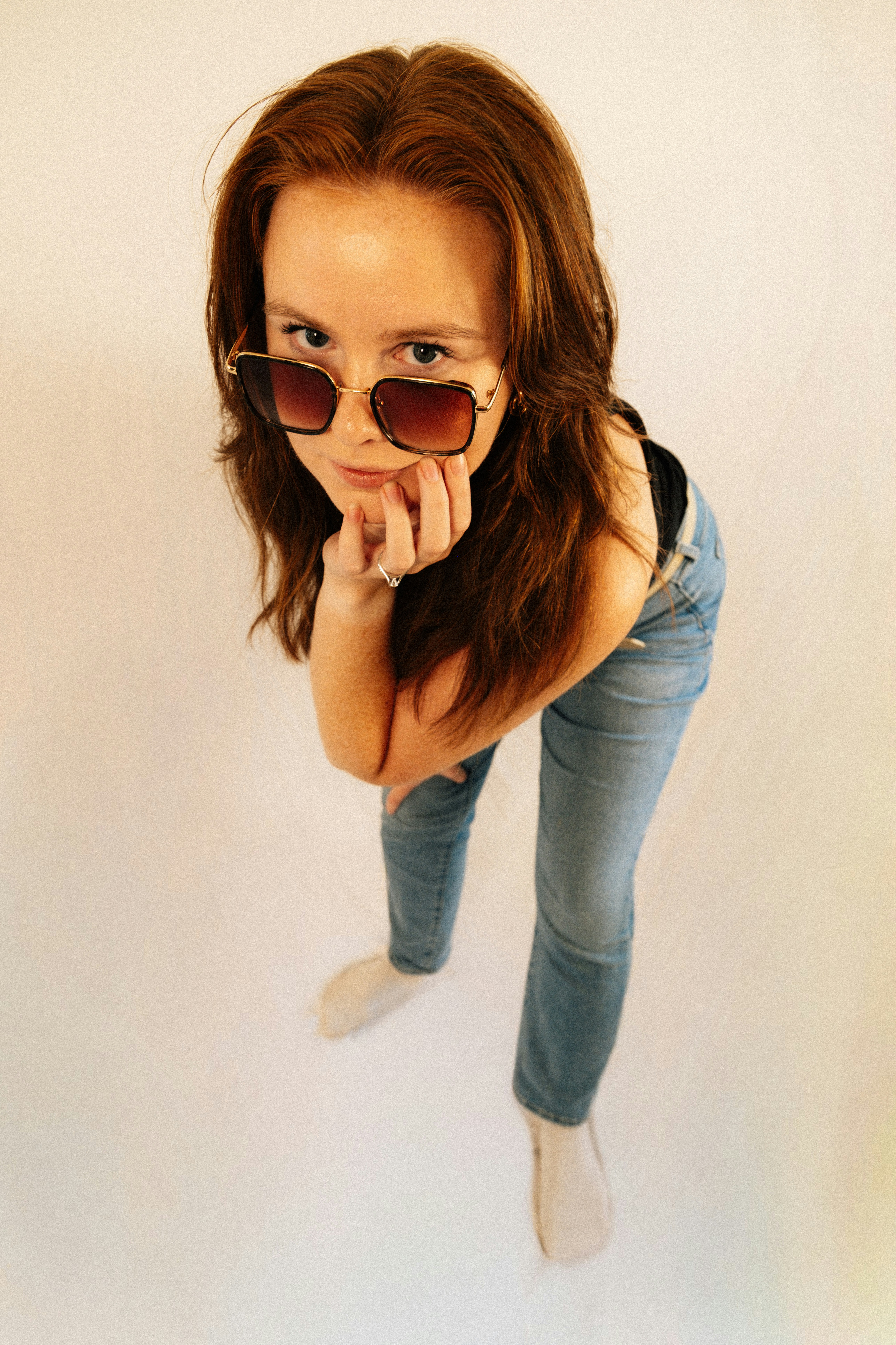Young woman with sunglasses leans forward