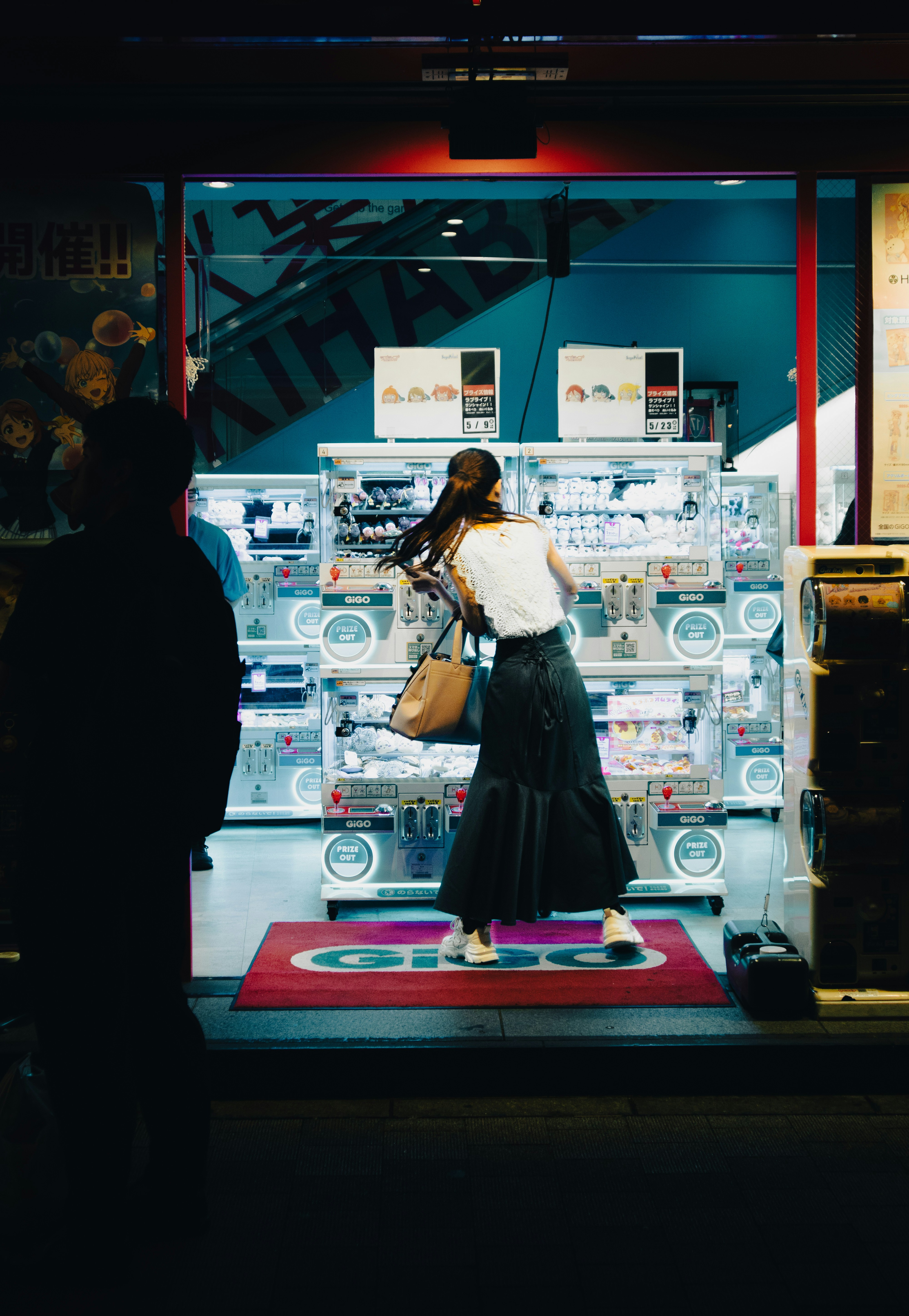 Woman playing claw machines at night