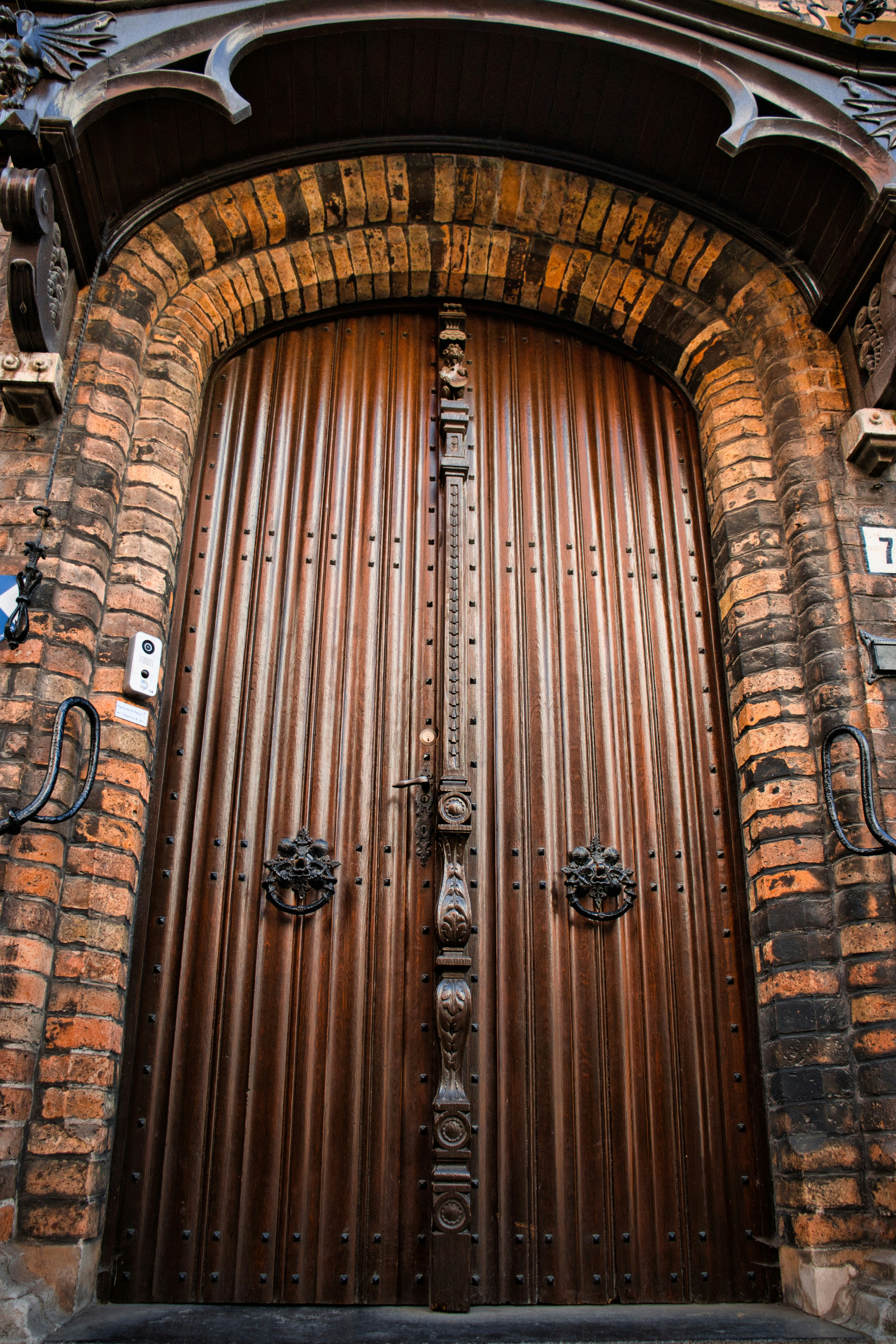 Ornate wooden double doors with brick facade