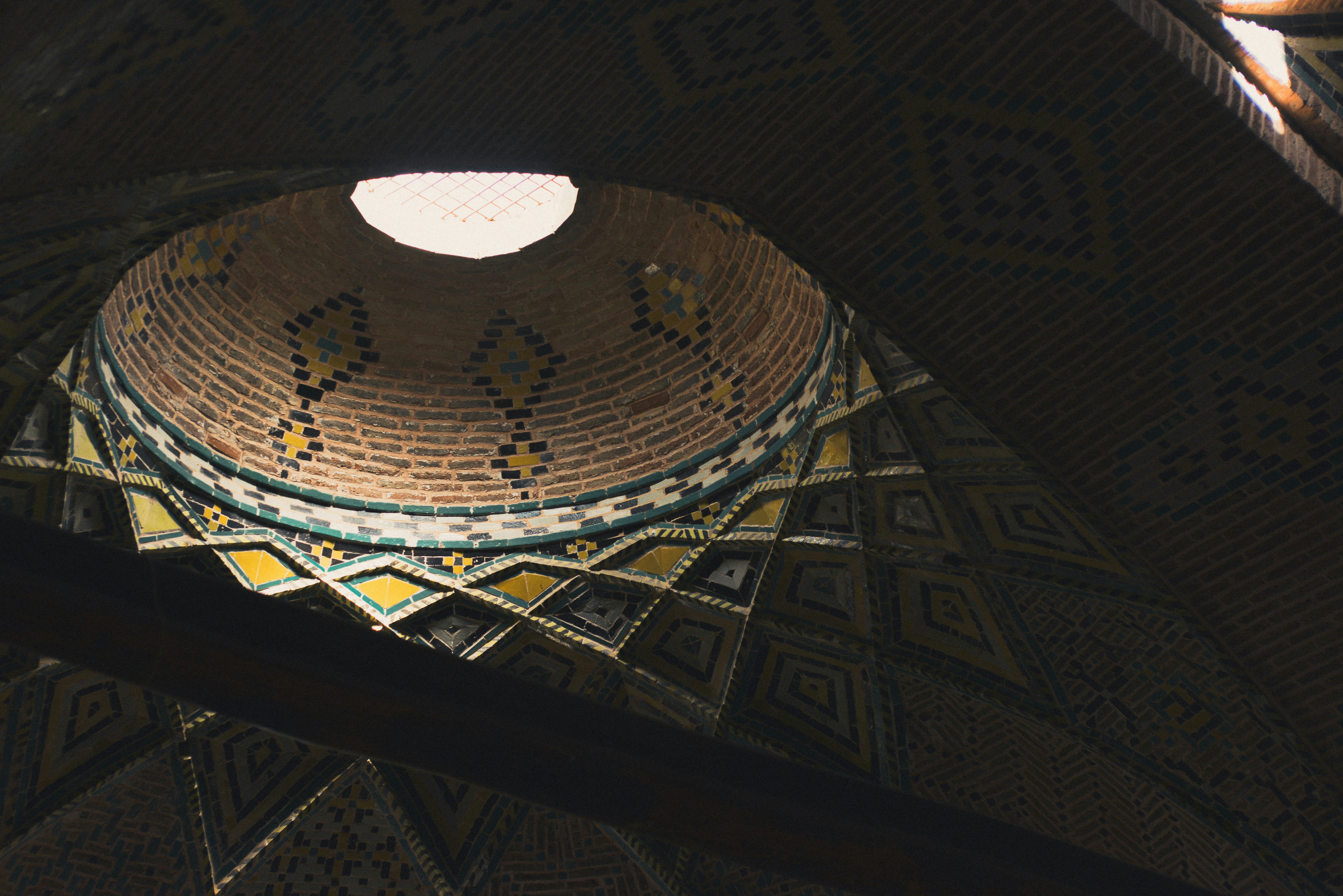 Intricate geometric patterns adorn an ornate domed ceiling.