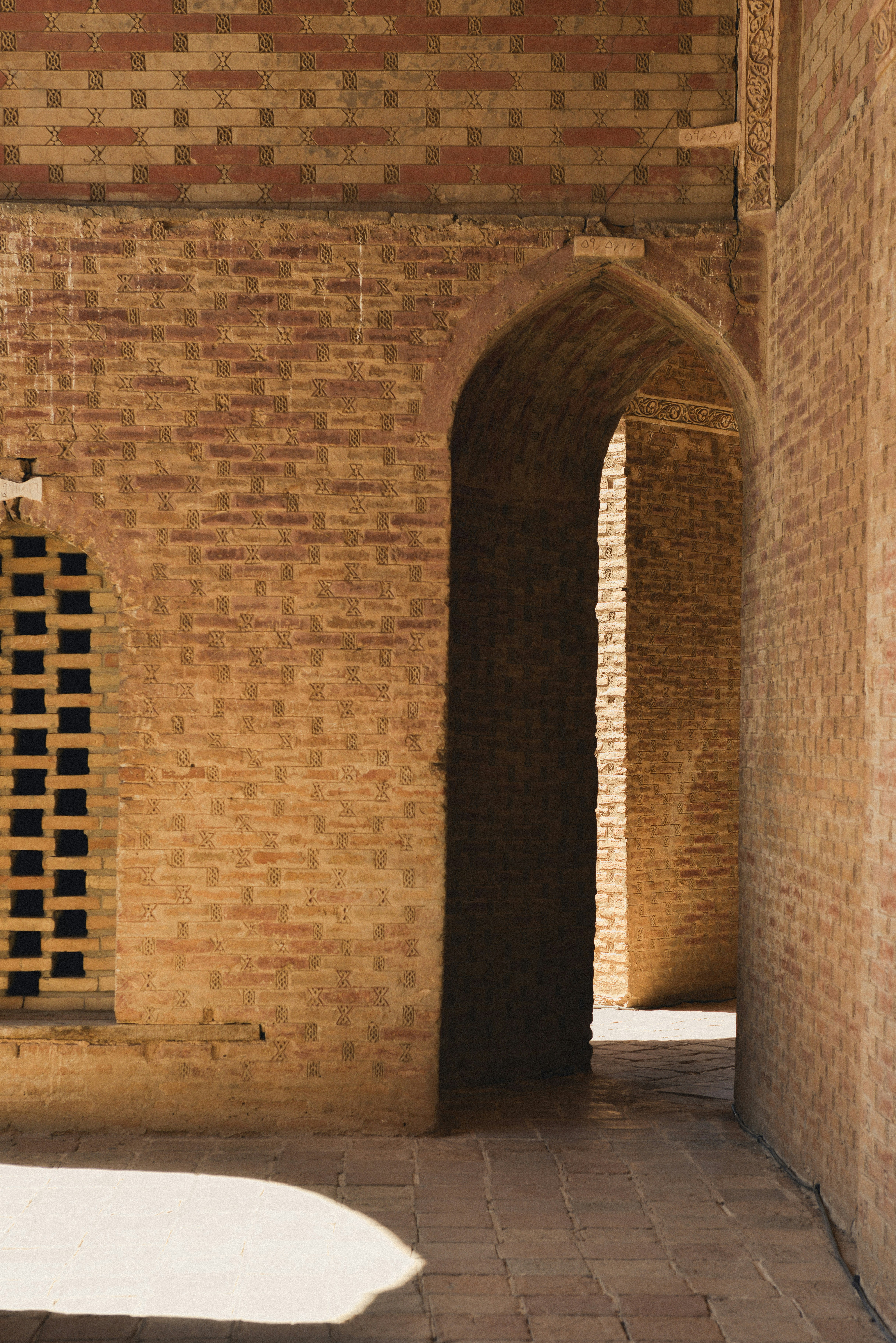 Arched passageway in a sunlit brick building